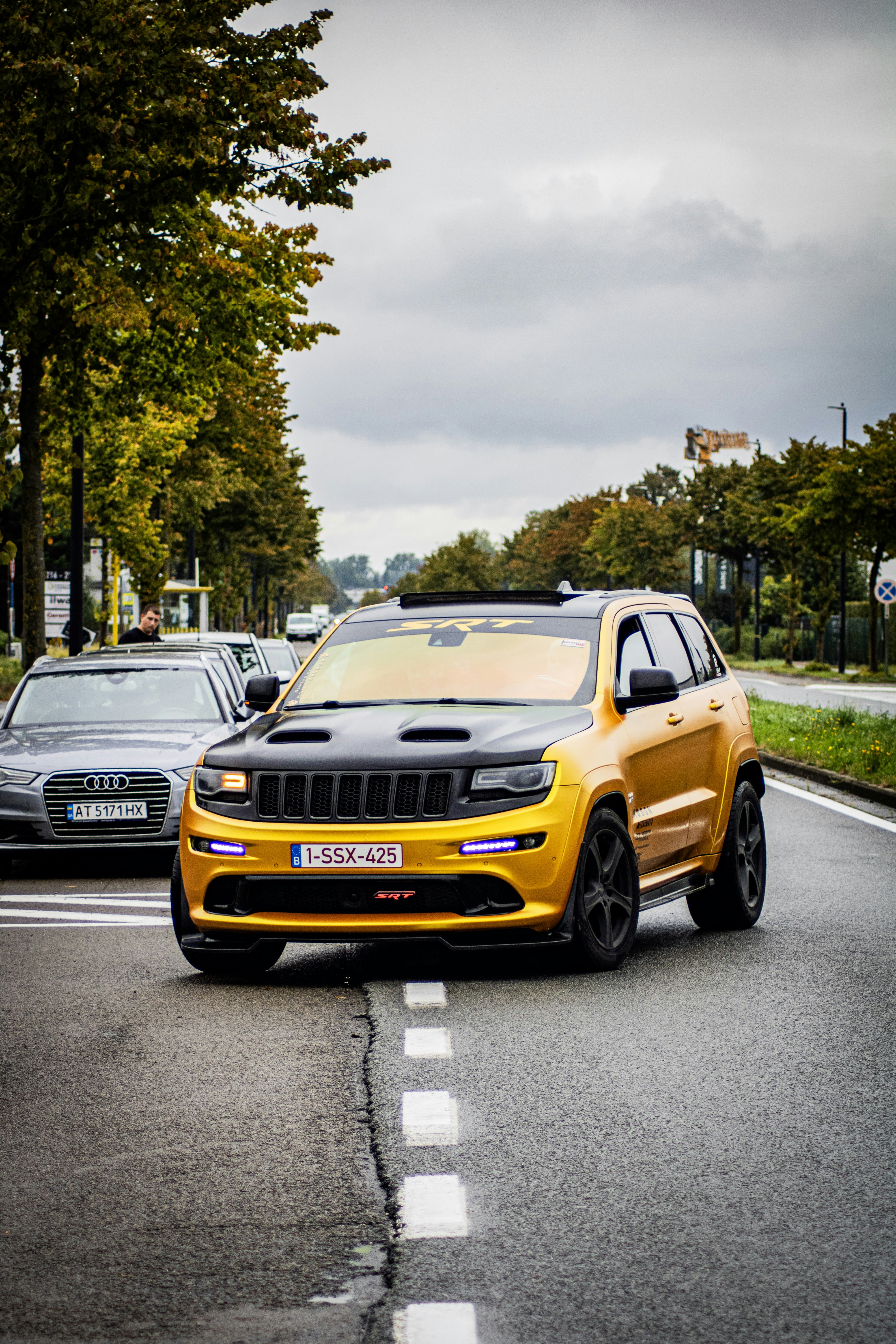Orange SUV Leading the Line: A City Street Standoff