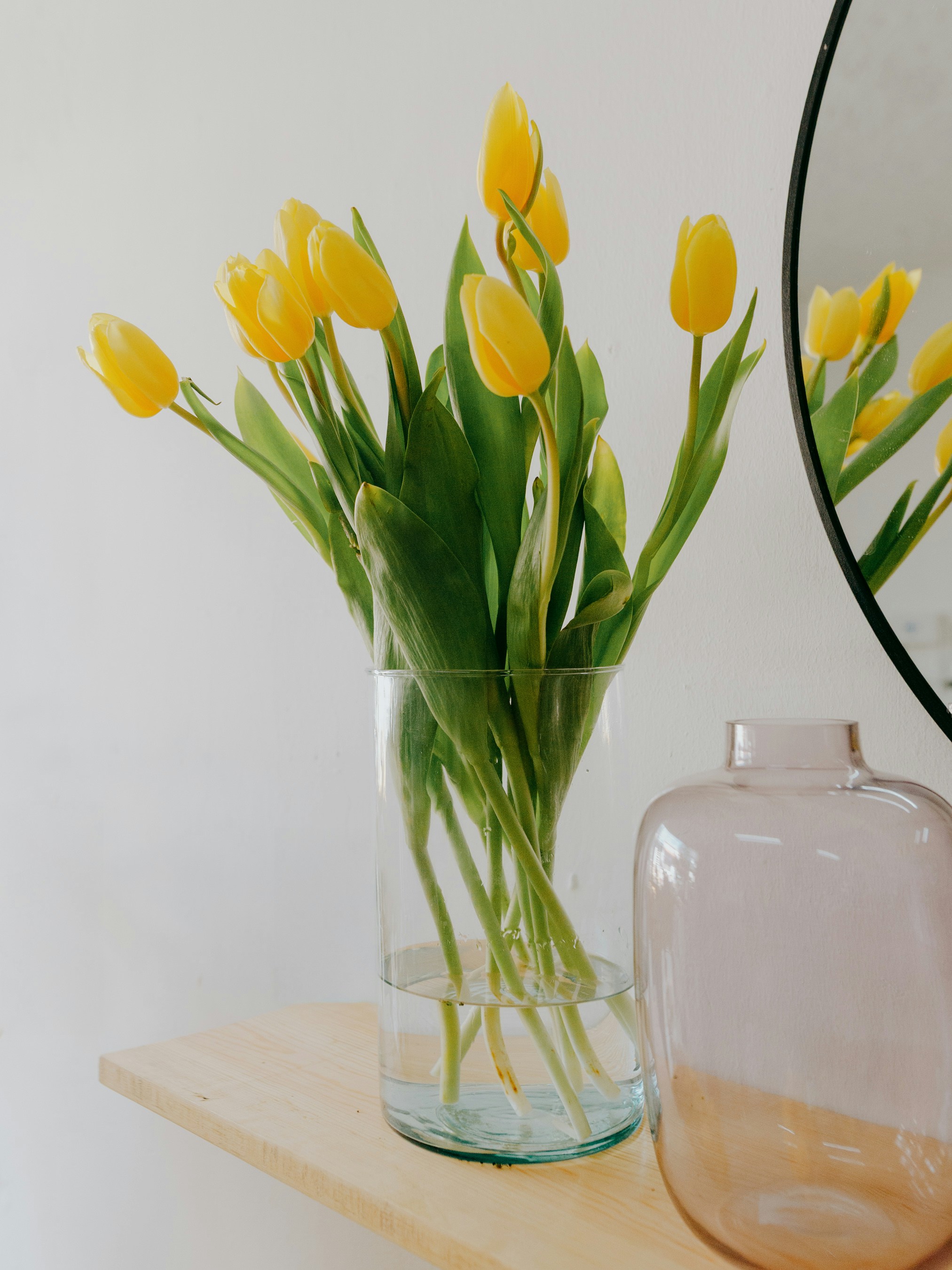 Yellow Tulips in Glass Vase with Reflective Round Mirror