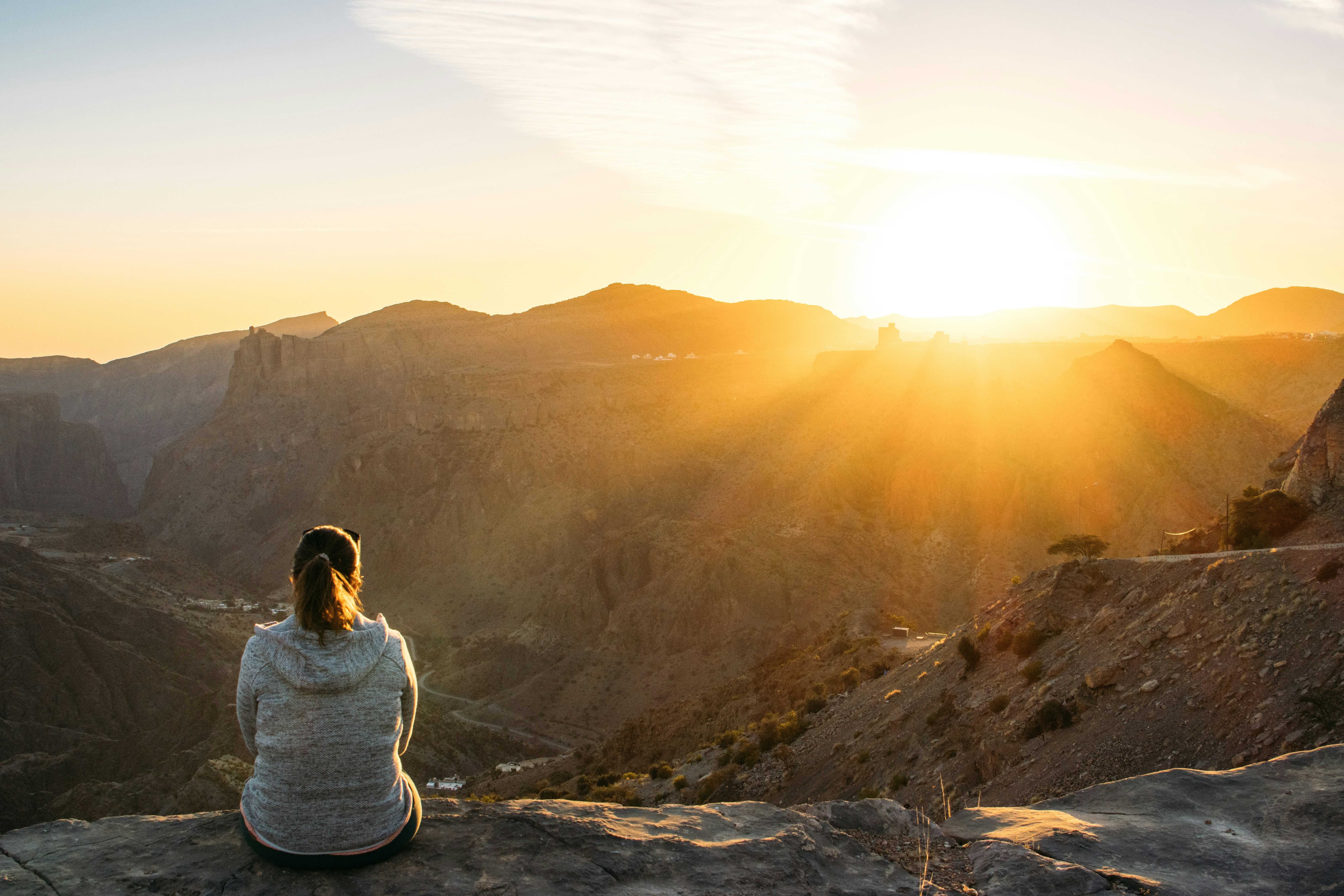 Sunlit Overlook: A lone viewer at the canyon edge