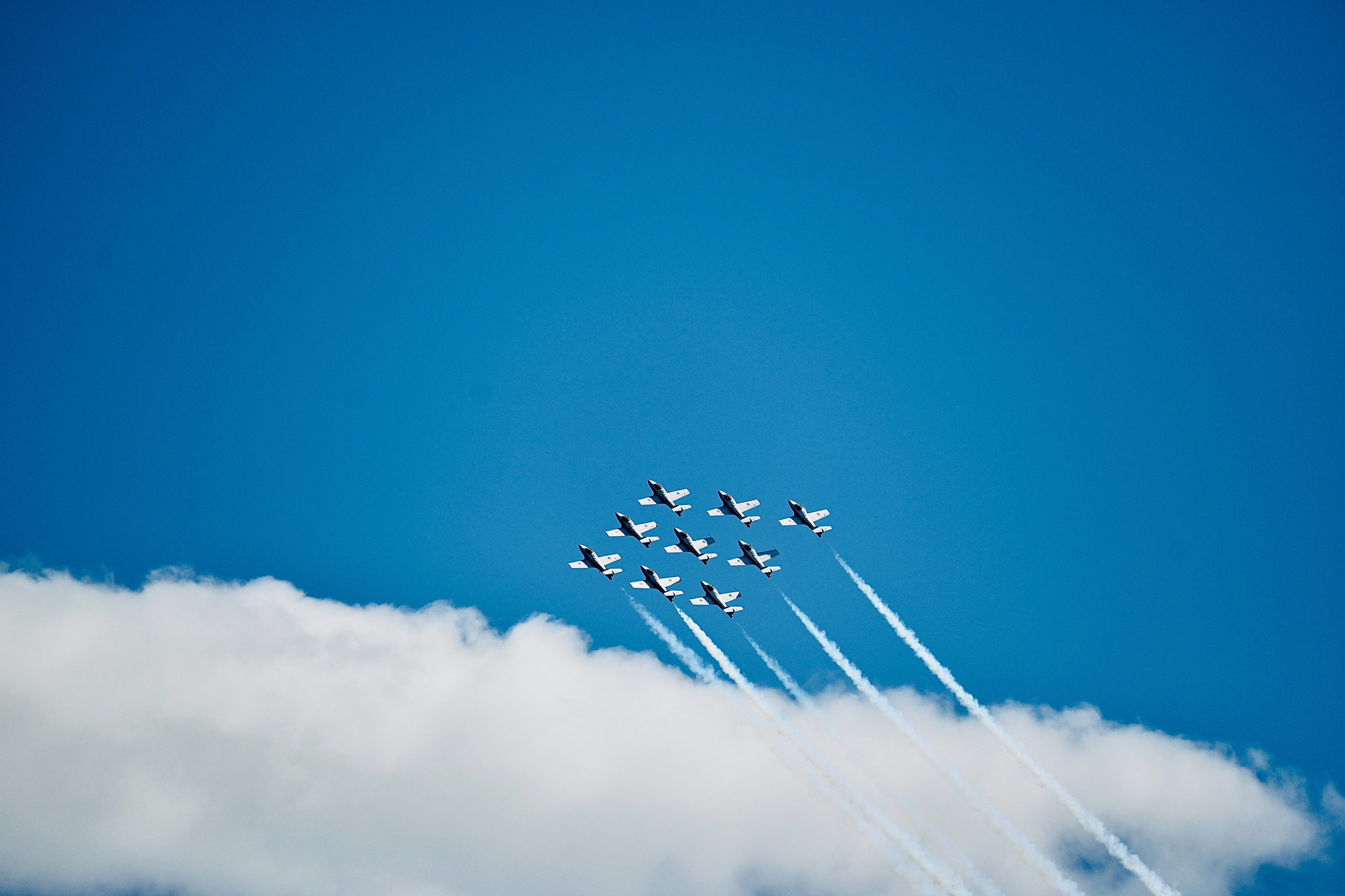 V-Formation Trail: Nine Jet Planes Slice Through Blue Sky