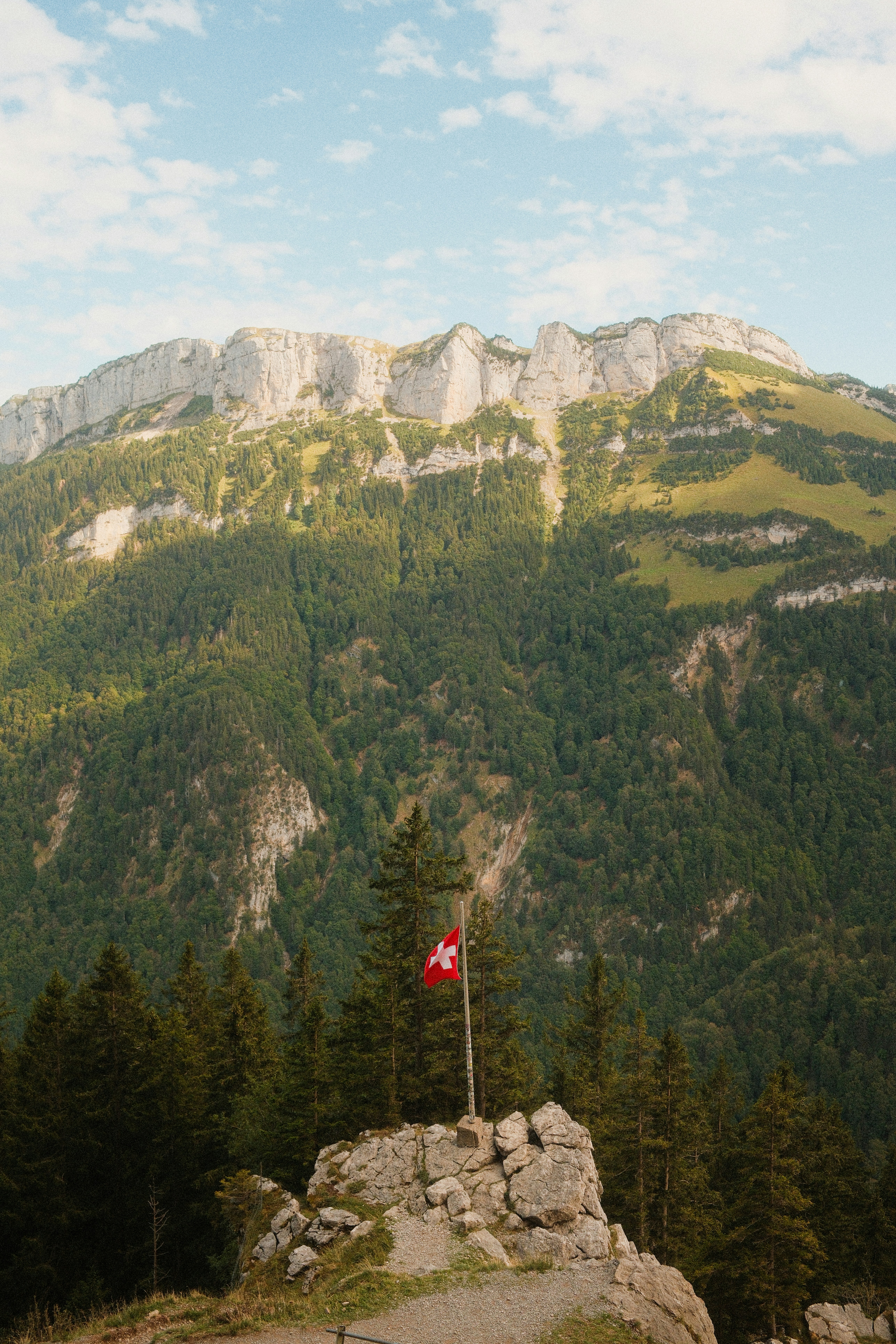 Flag atop the jagged cliff: a lone symbol against mountain majesty
