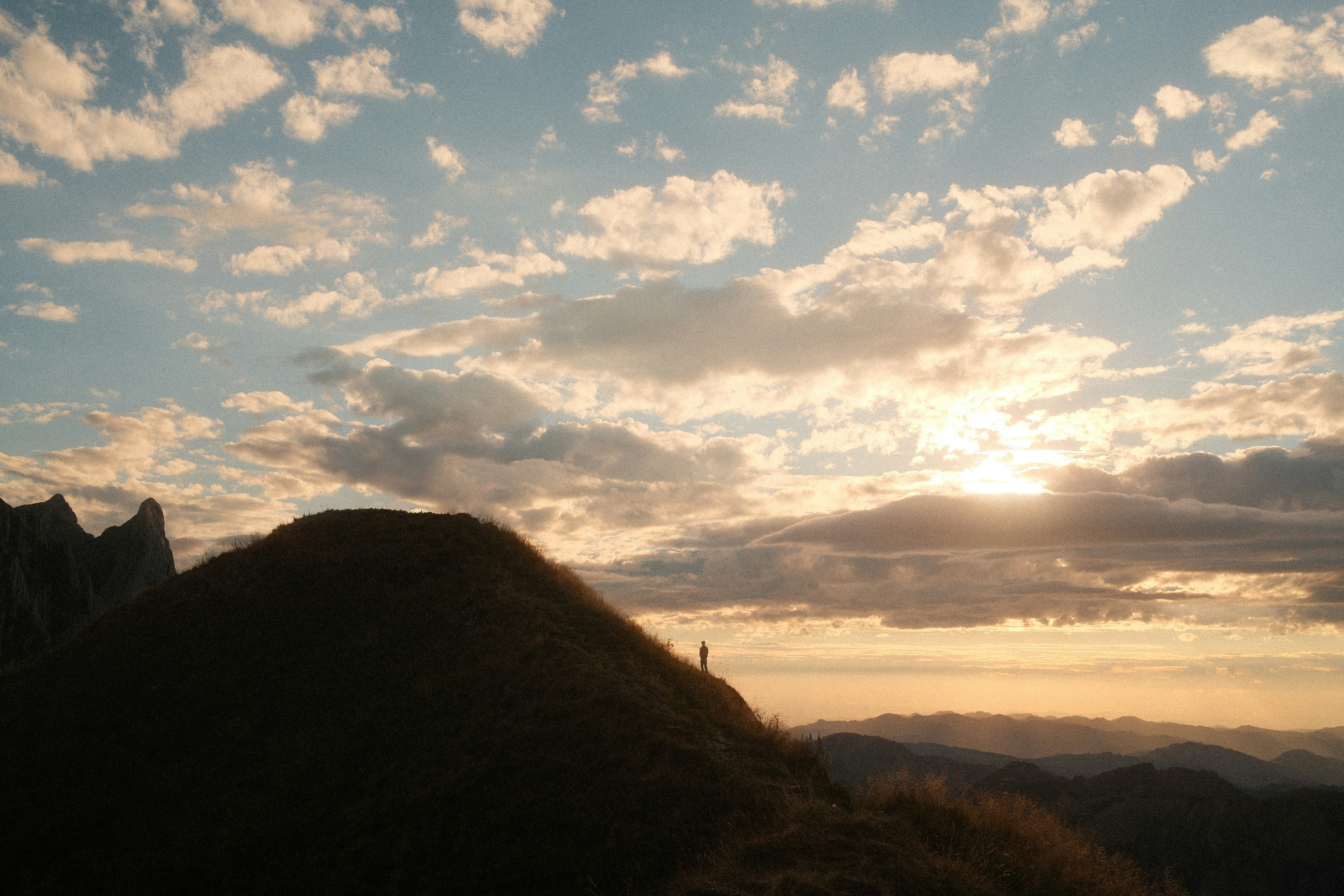 Sunlit Summit: A lone figure atop the ridge at golden hour