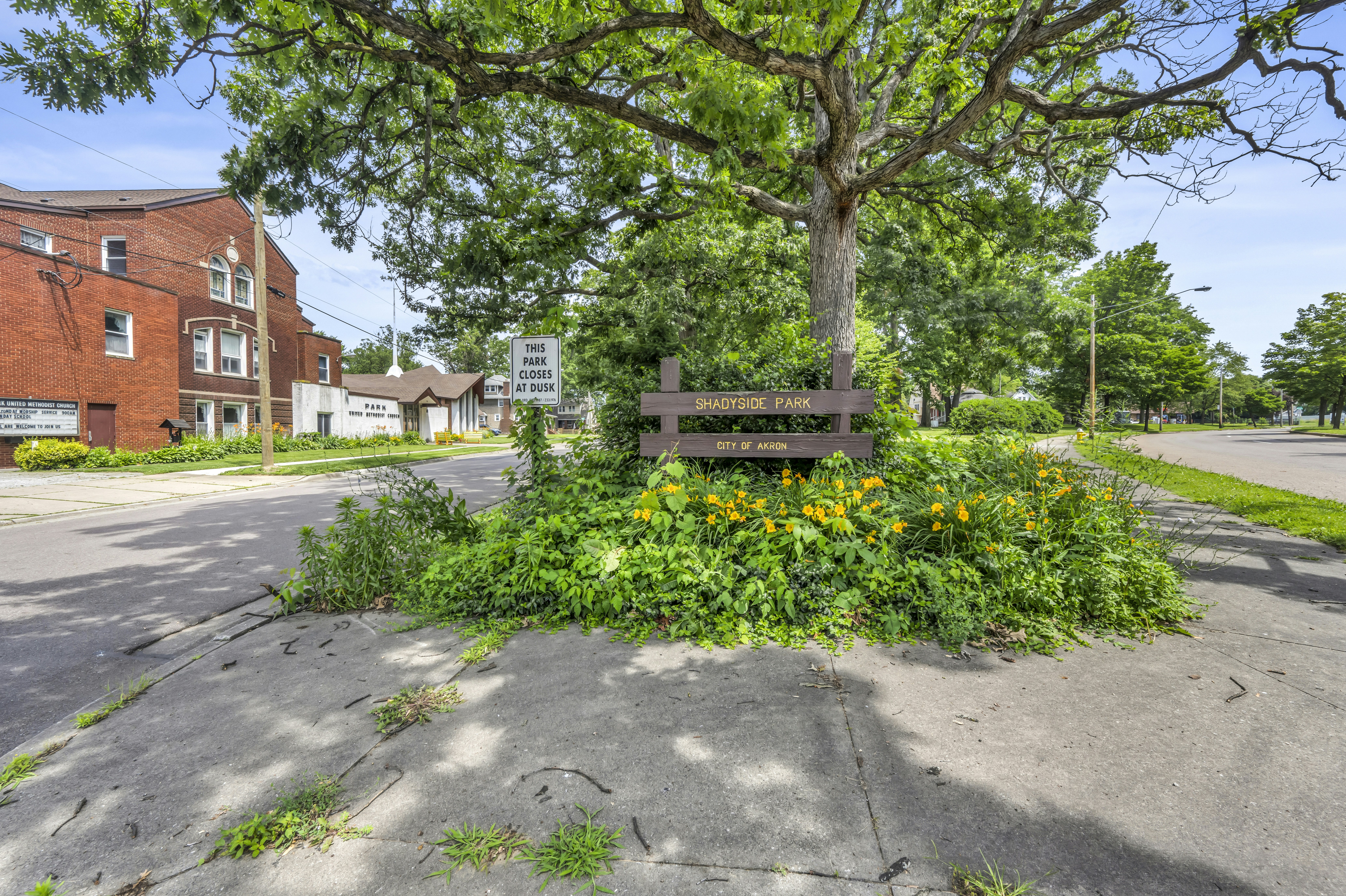 Urban roundabout garden sign amid flowery verge