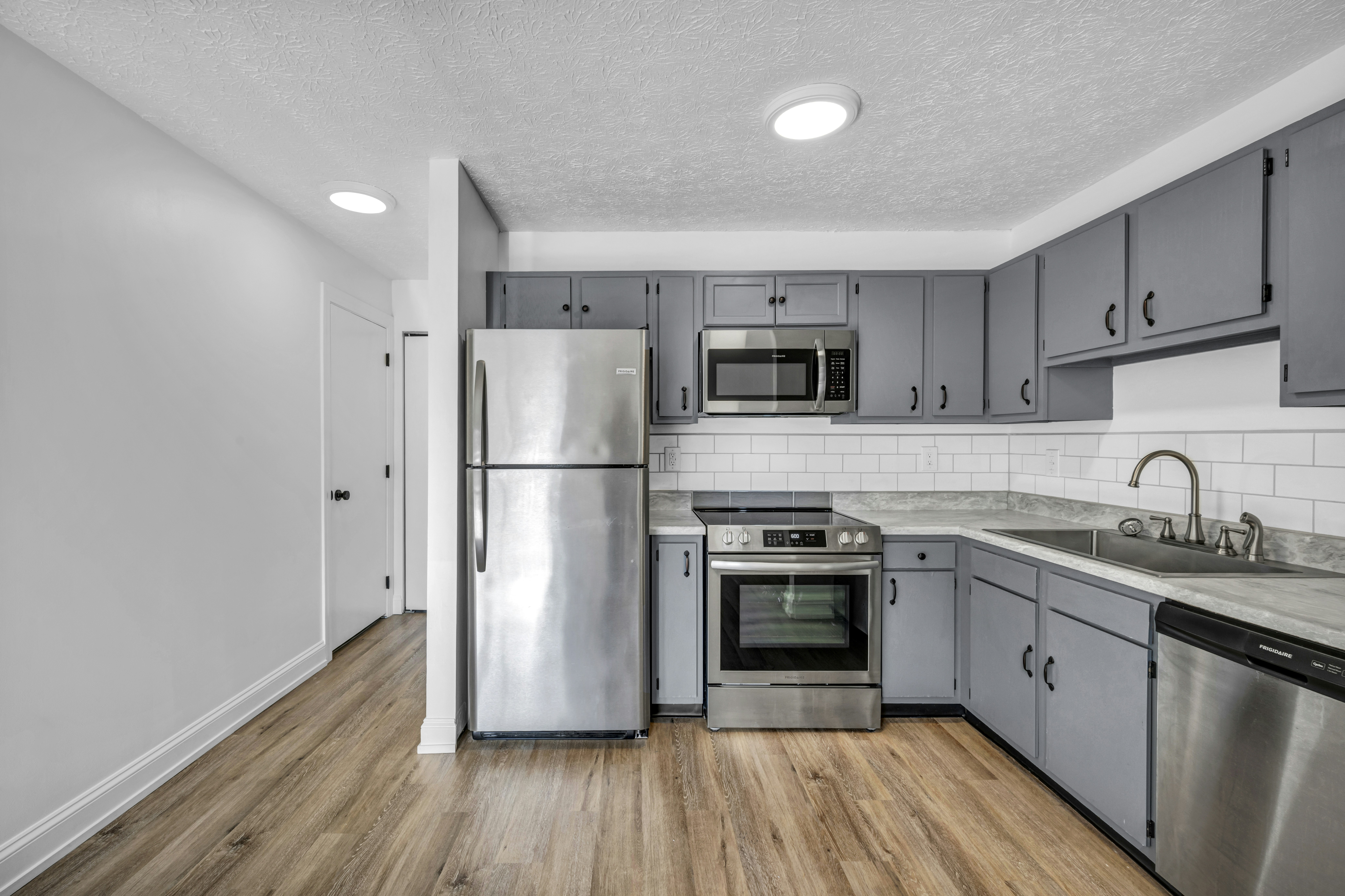 Sleek urban kitchen with stainless steel appliances and pale blue-gray cabinets