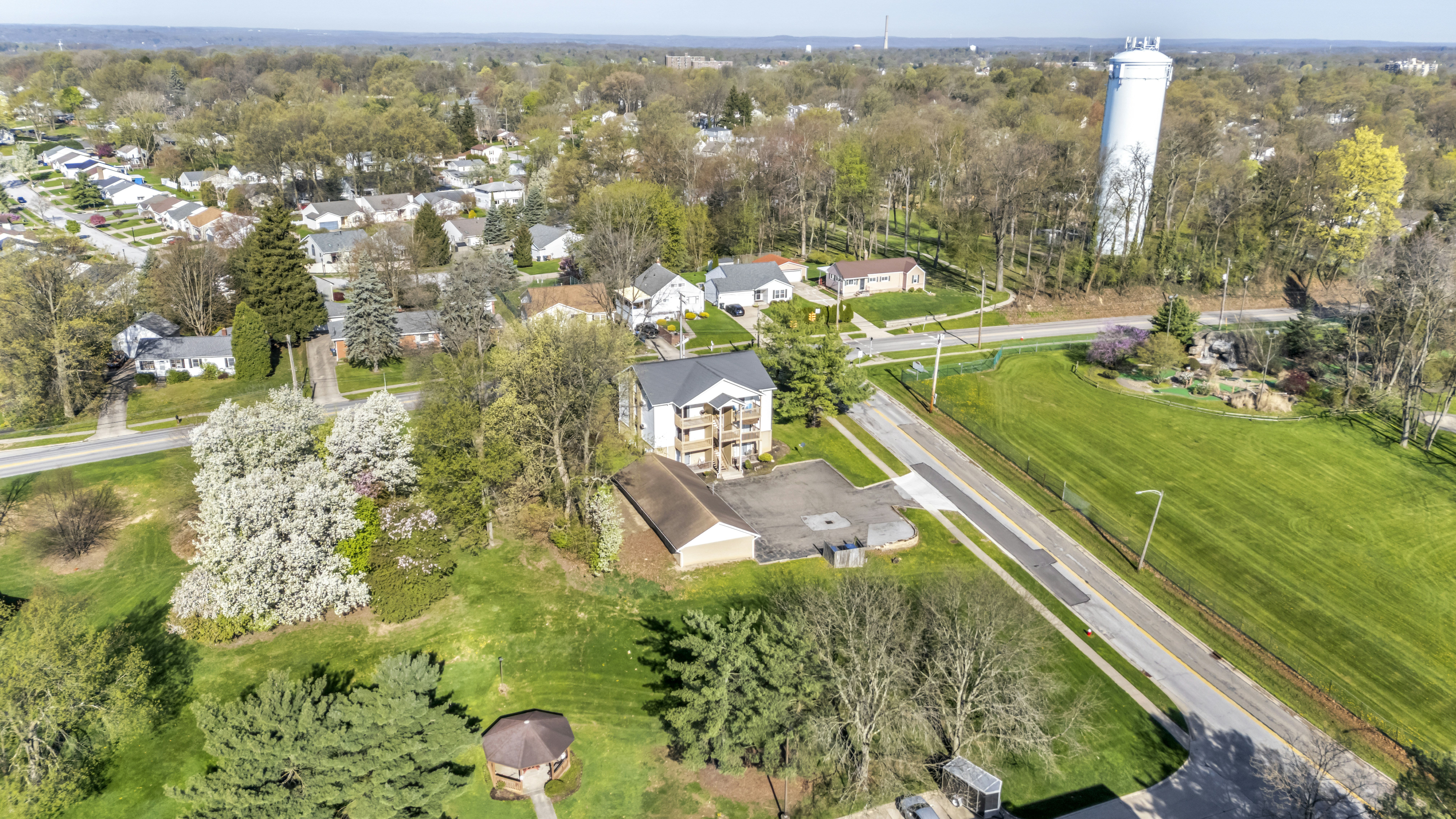 Aerial Quiet: Suburban Campus Amid Green Rows and Clock Tower