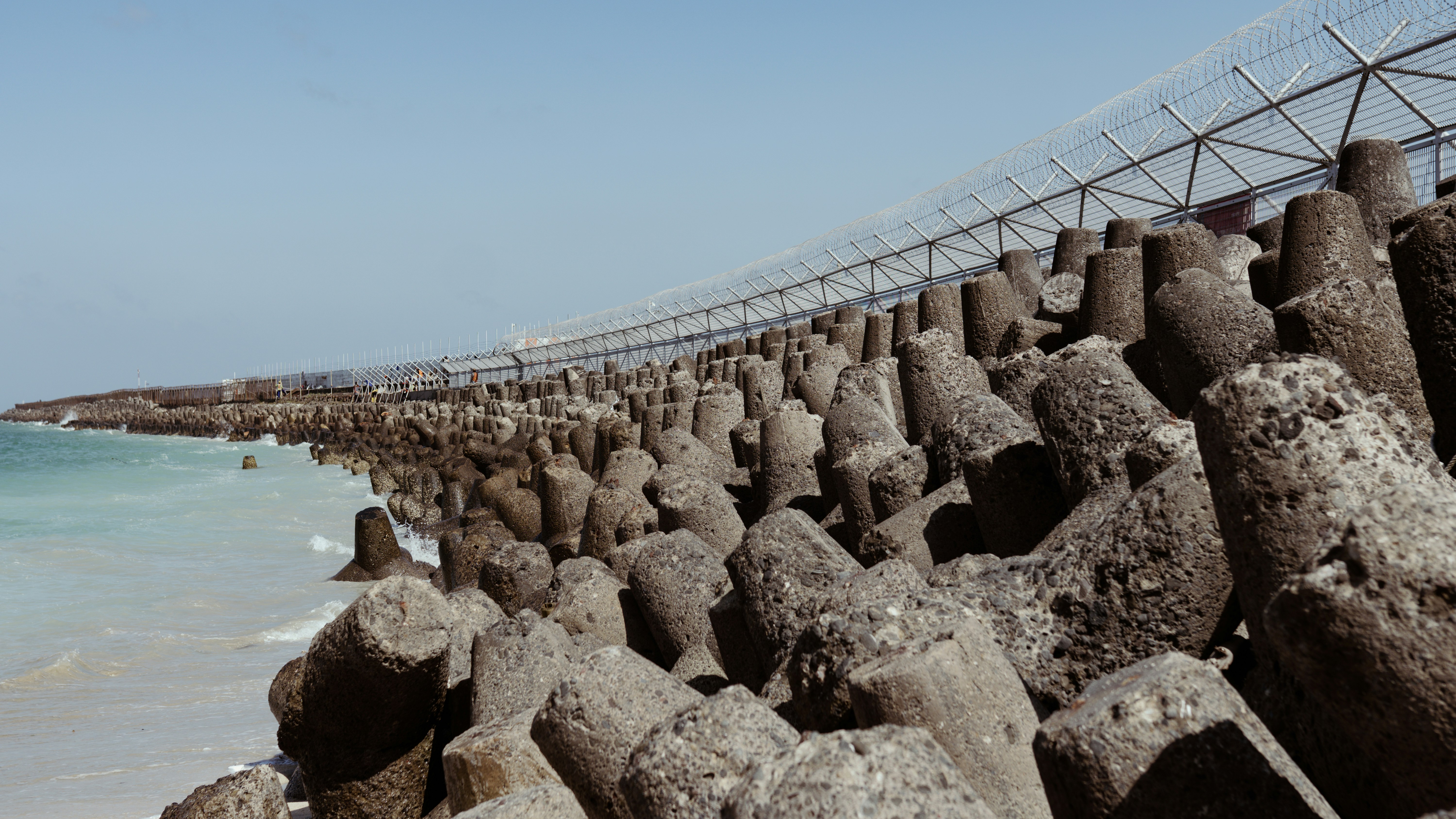 Breakwaters and Tide-Touched Grids Along a Turquoise Shore