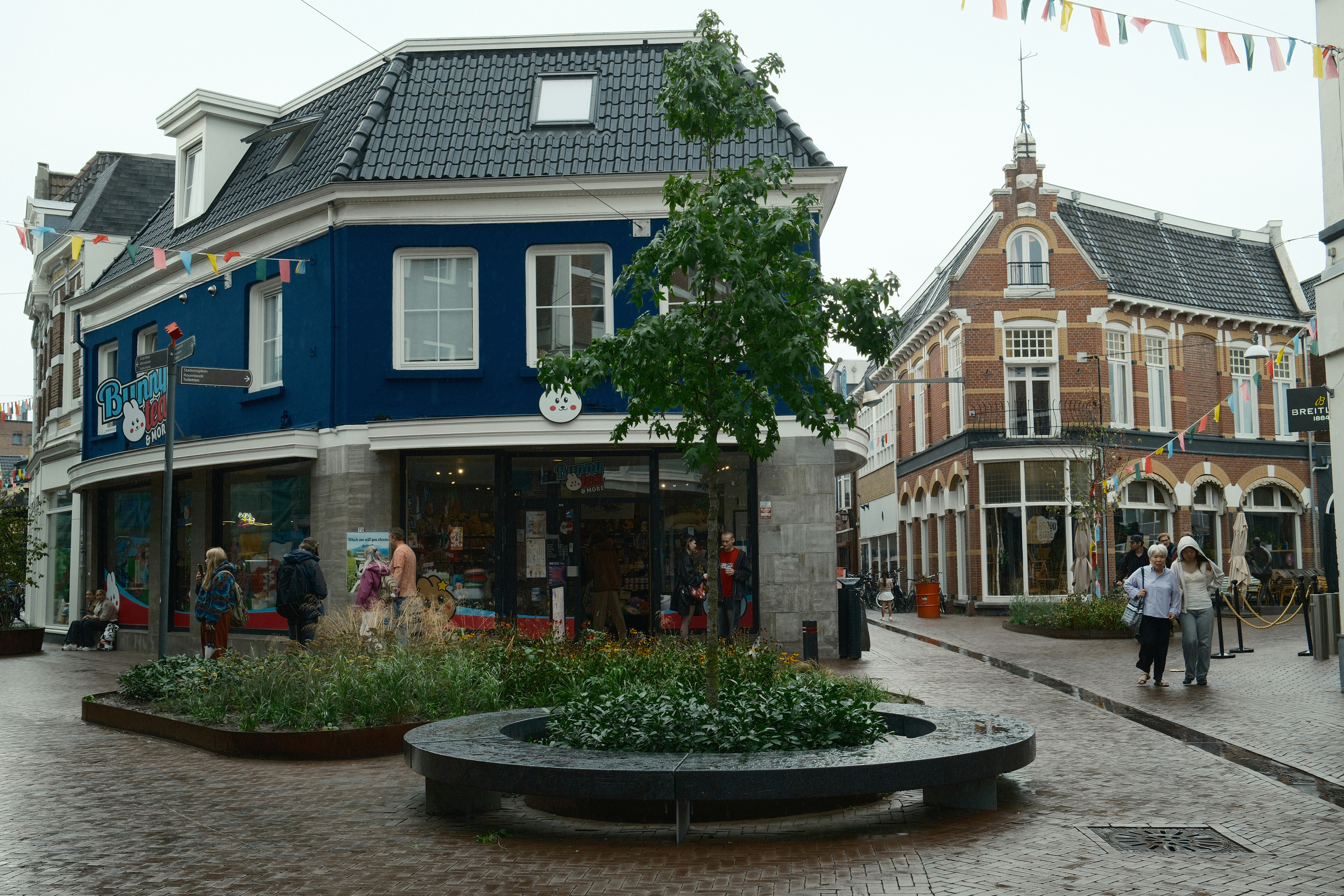 Colorful Corner: A Quiet Pedestrian Moment by the Blue Shopfront