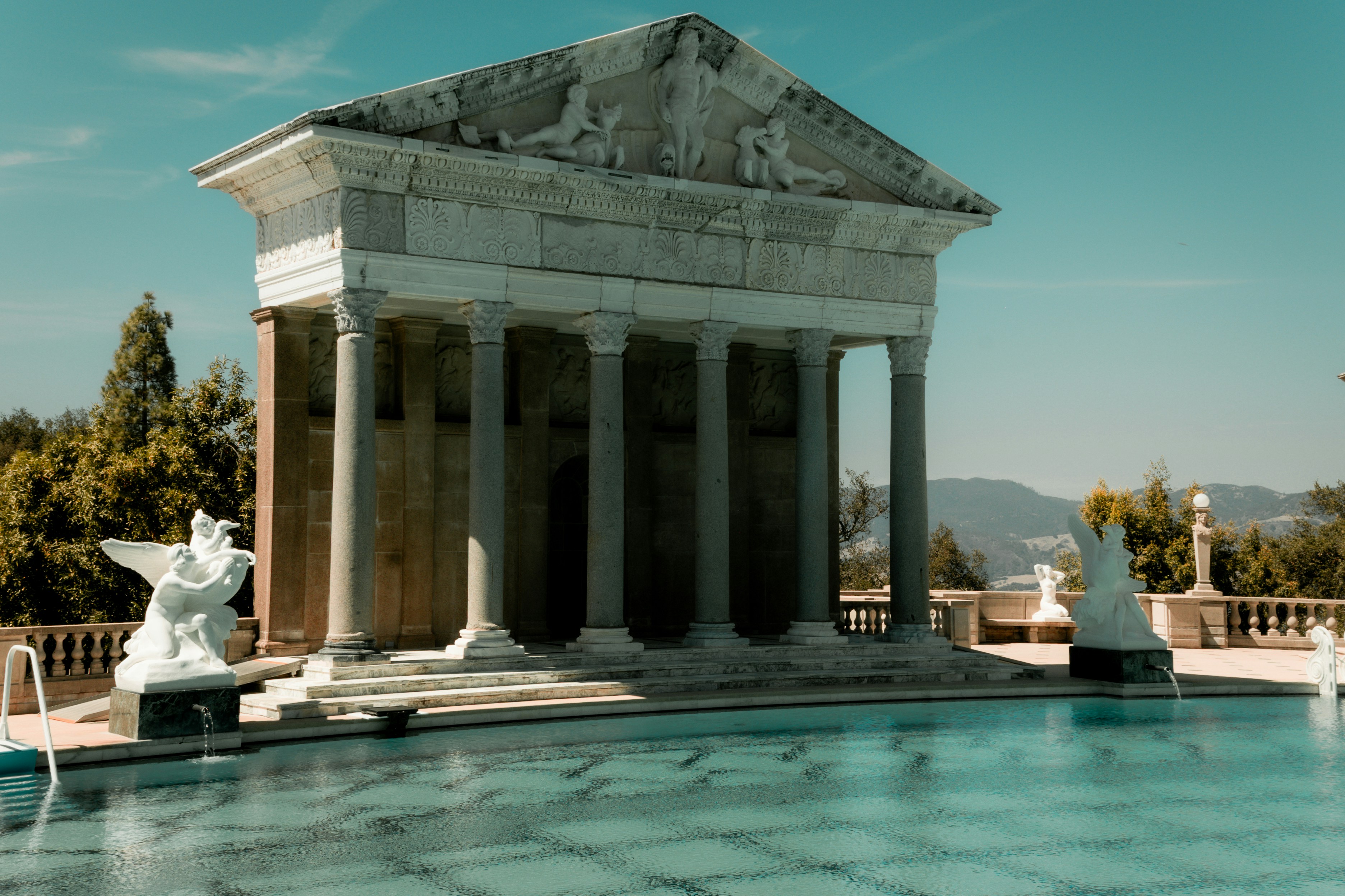 Temple of Light over the Pool: A Classical Pediment Framed by Sculpted Wings