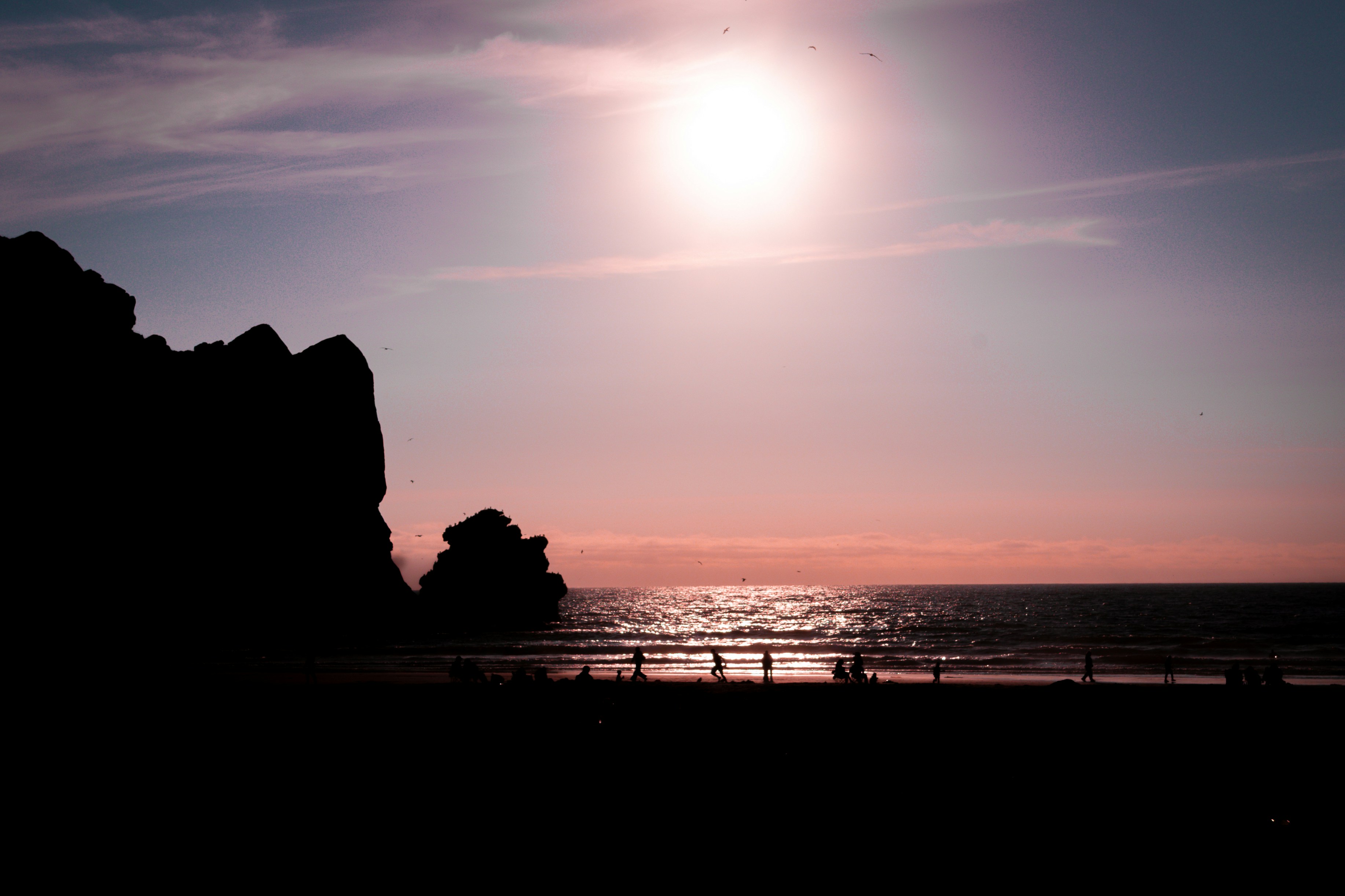 Silhouette at Sundown: Coastline and Boardwalk Under a Soft Sunset