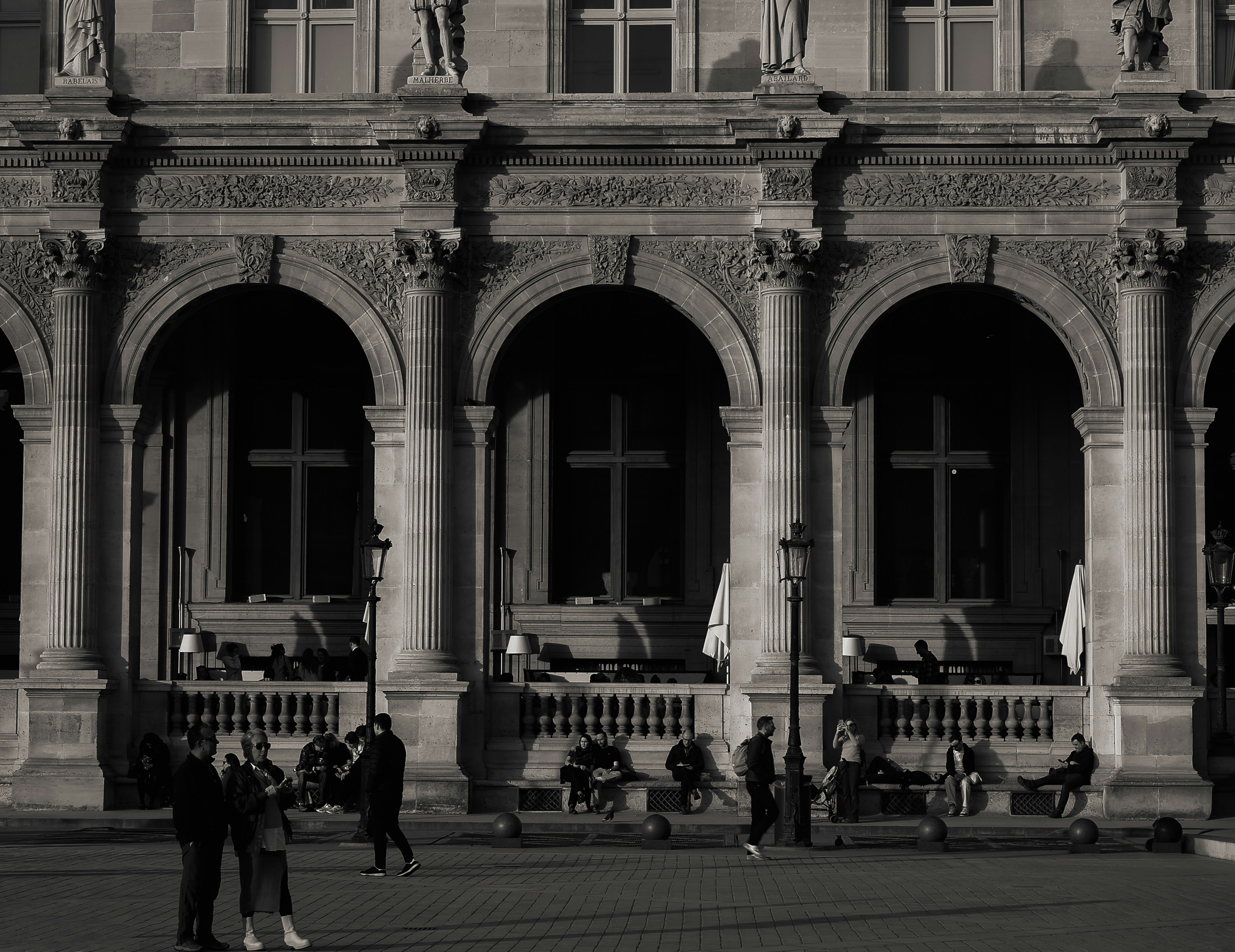 Arched Facade, Silent Pedestrians: A London Courtyard in Monochrome