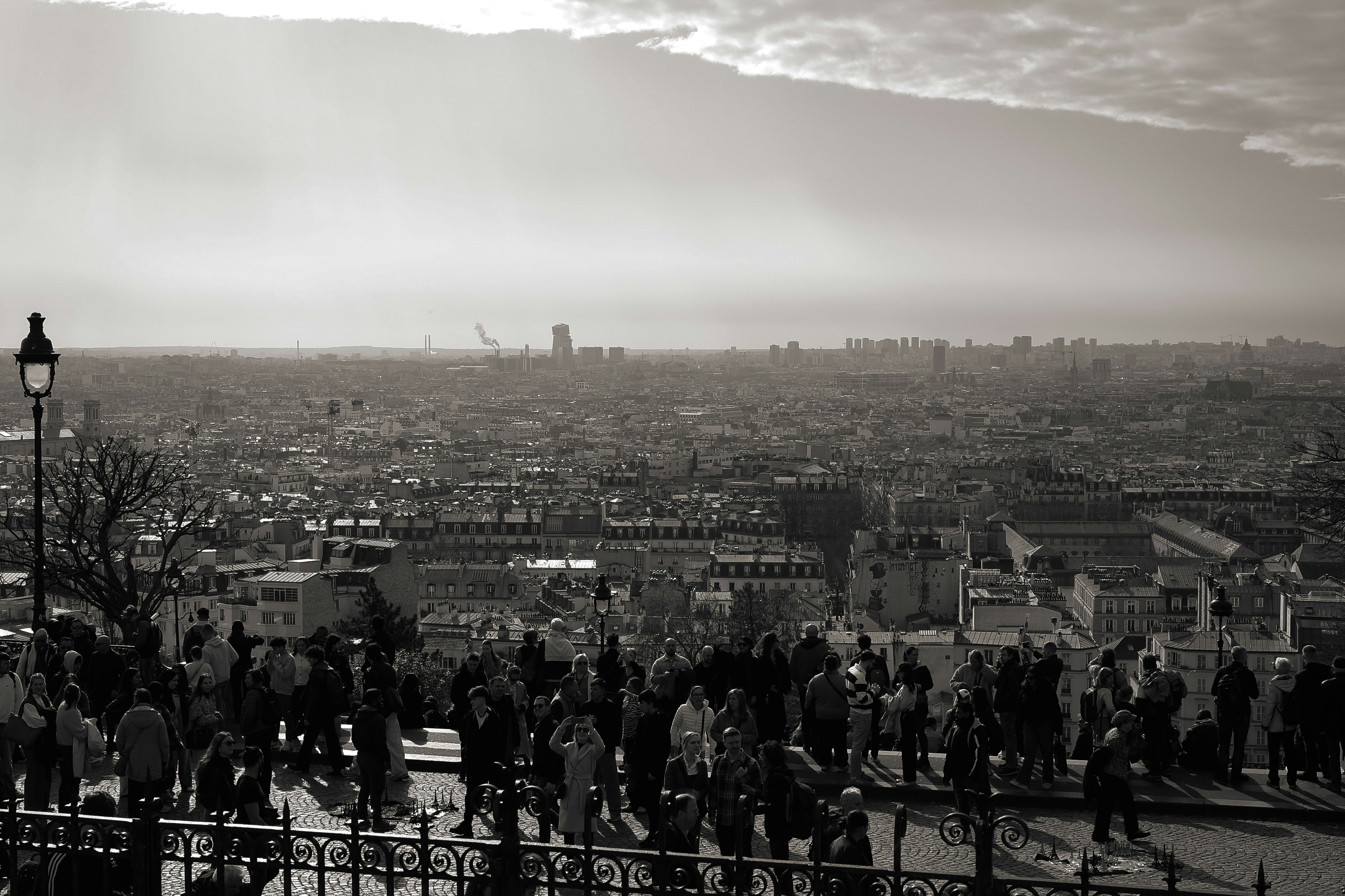 Rooftop Crowd Overlooking a Distant Cityscape at Dusk