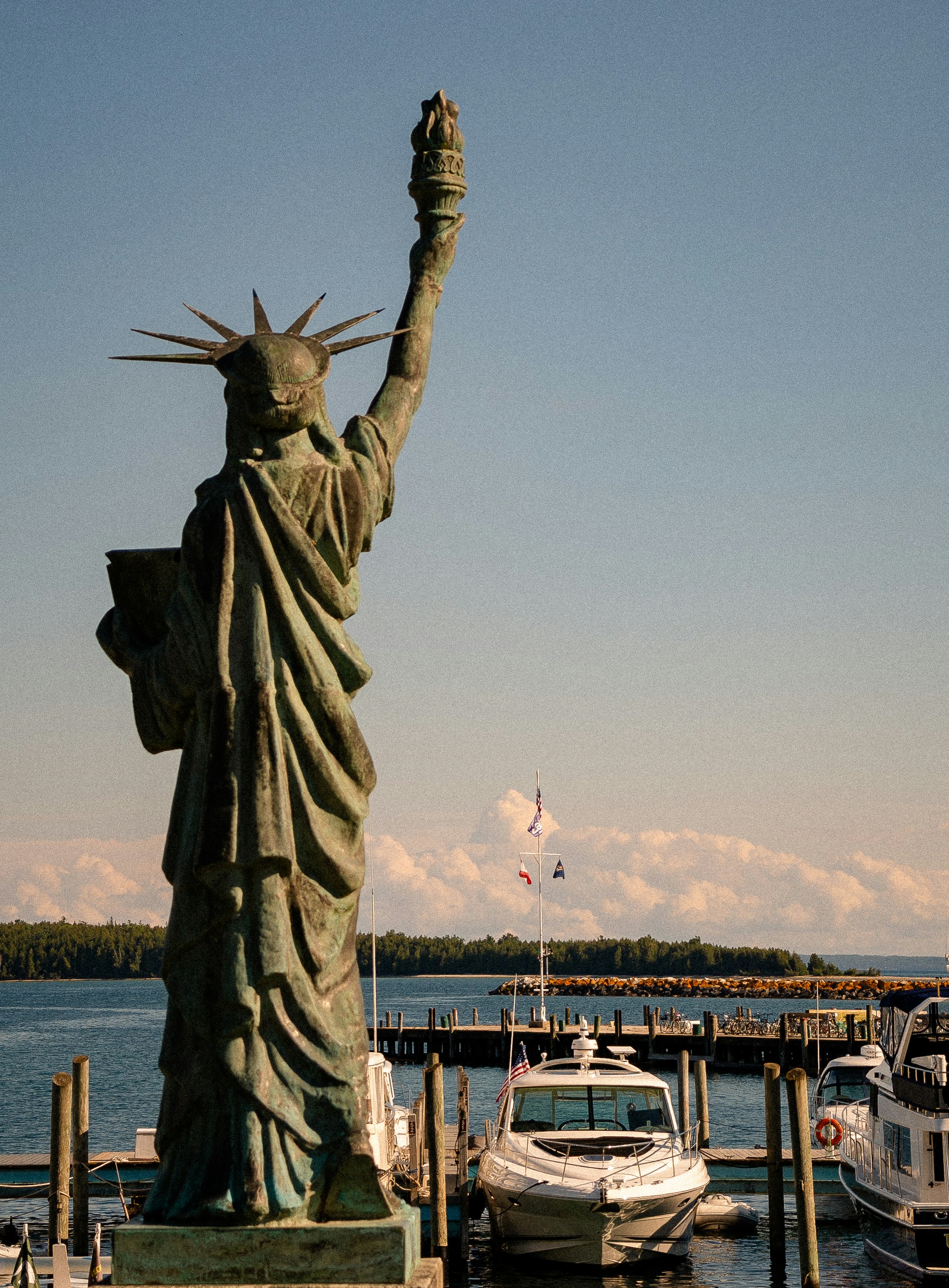 Statue silhouette over calm harbor: a morning at the pier