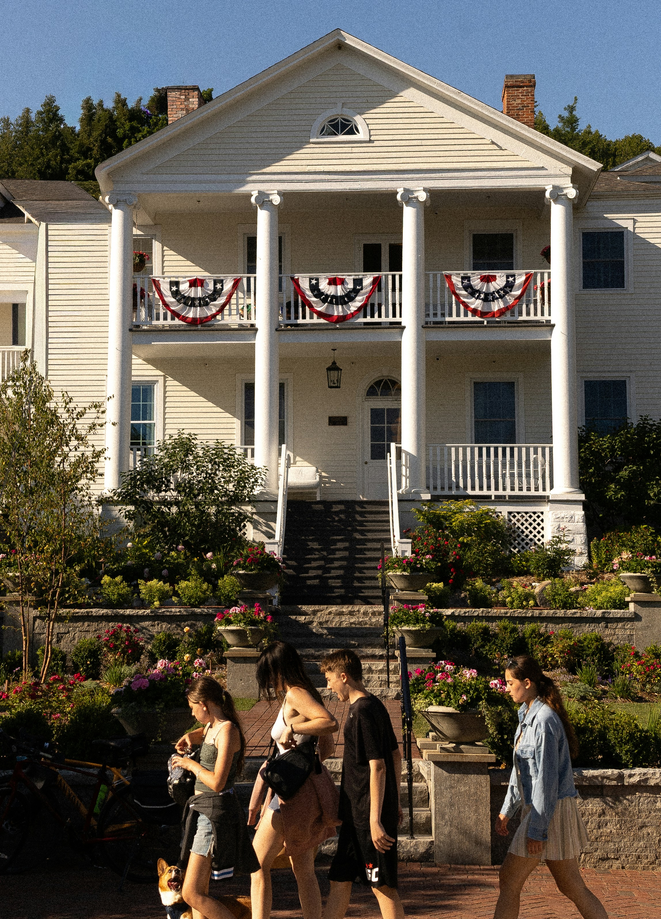 Front Porch Portrait: A Southern House with Patriotic Banners and Strolling Crowd