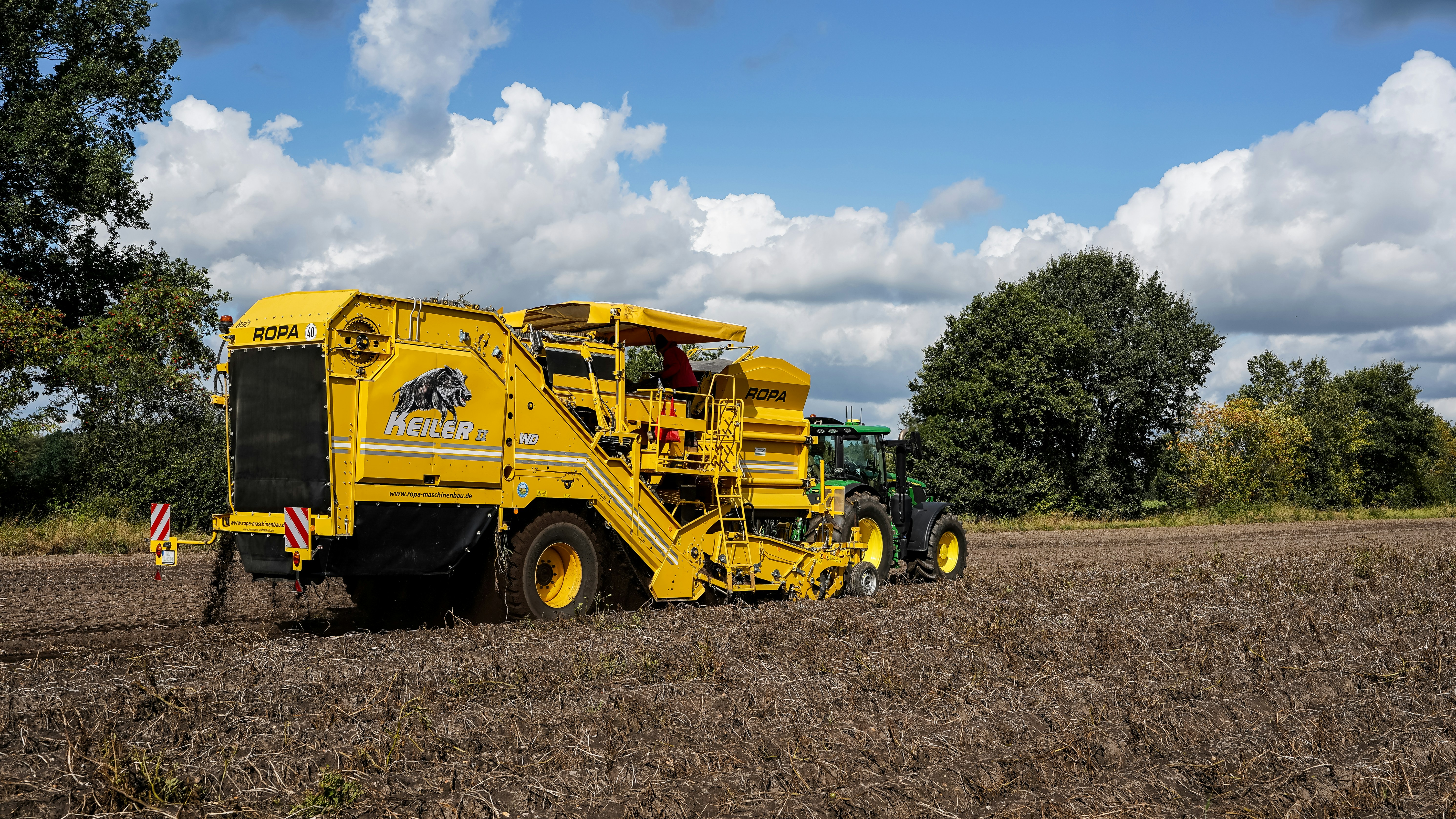 Harvest Machinery in Field: A Yellow Prowler Takes the Lead