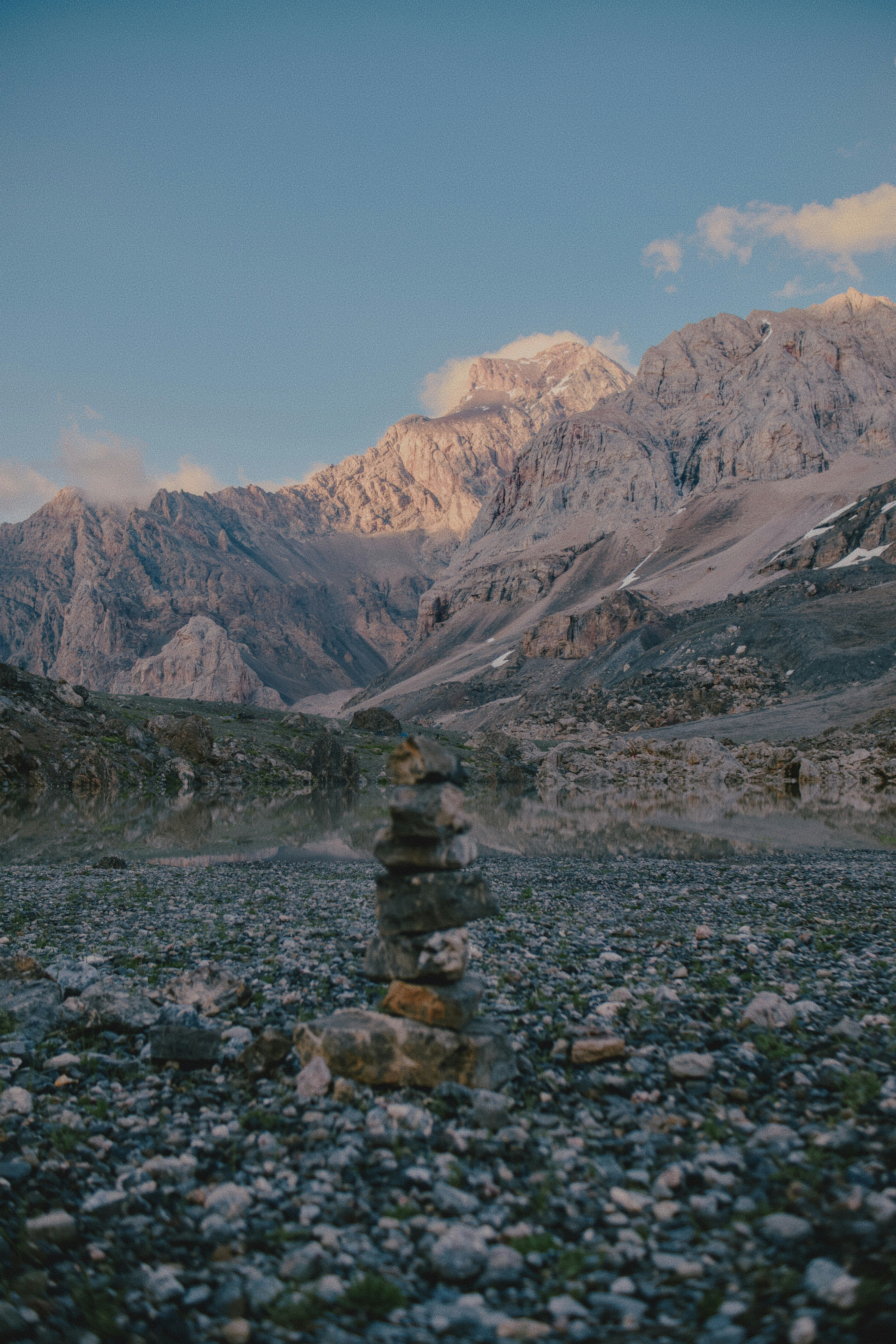 Stacked Stones Beneath A Mountain Ridge at Twilight