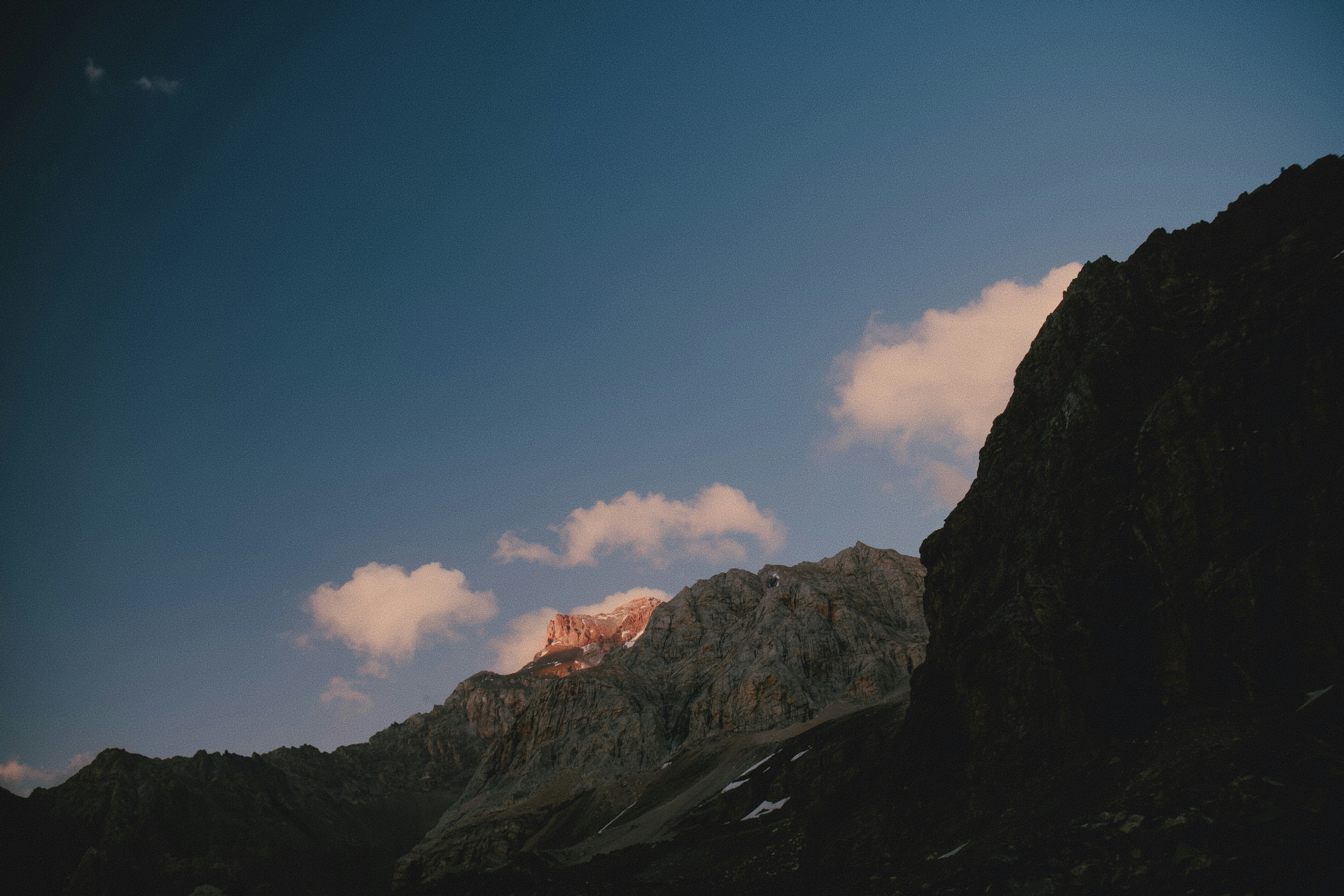 Snow-kissed ridge catching the last light over a looming cliff