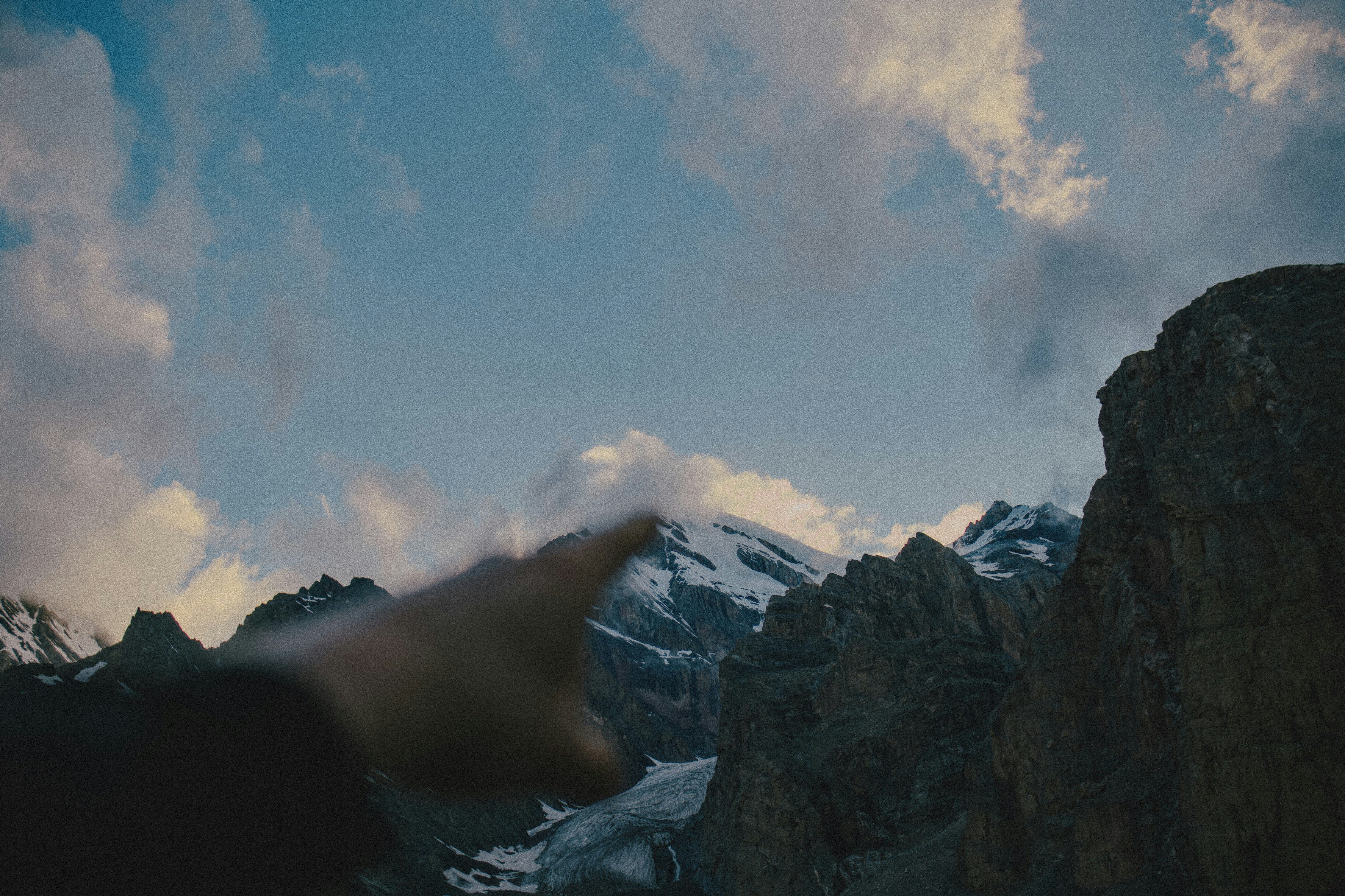 A distant summit framed by a reaching hand