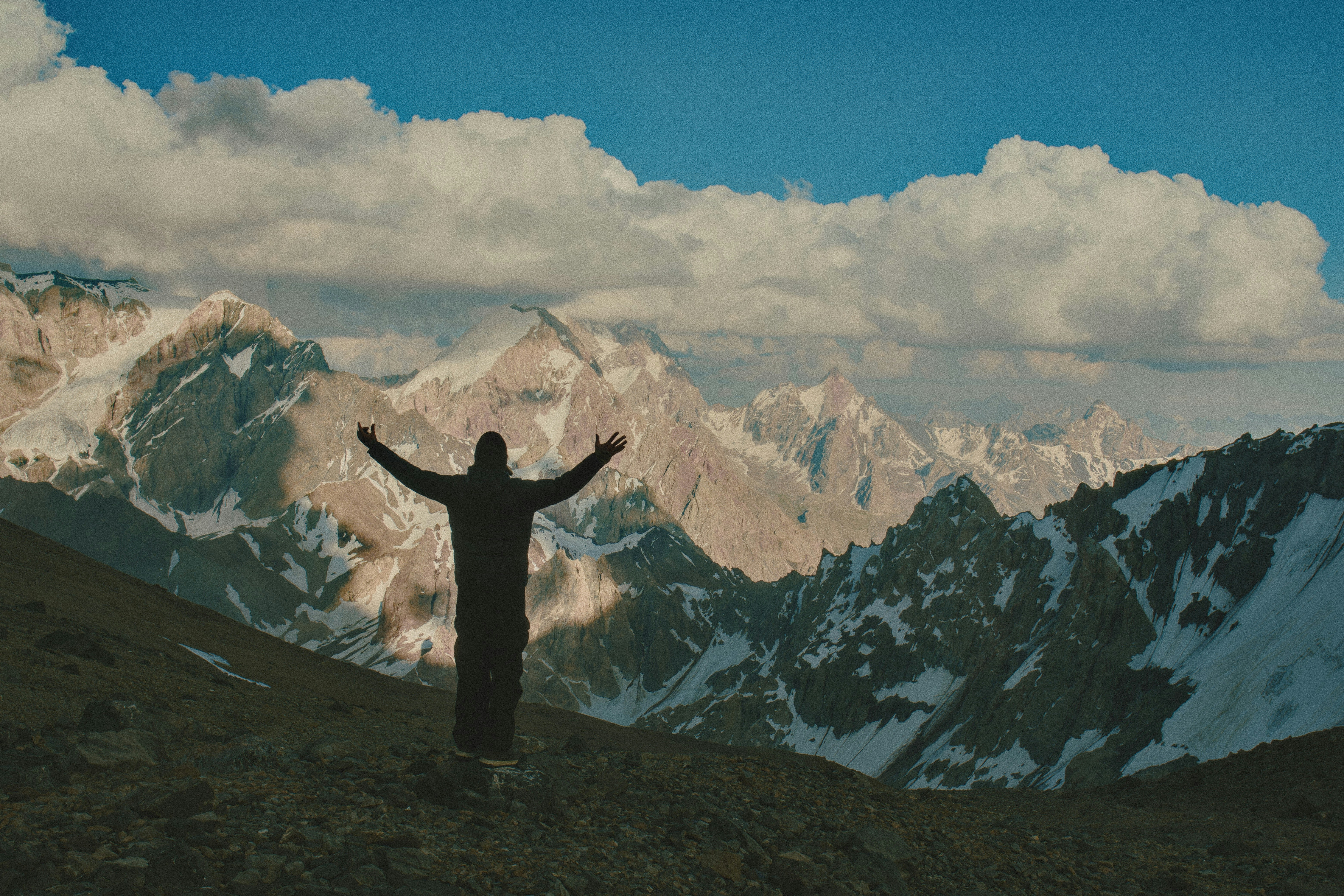 Silhouette on the Ridge: A Lone Figure Embracing Alpine Majesty