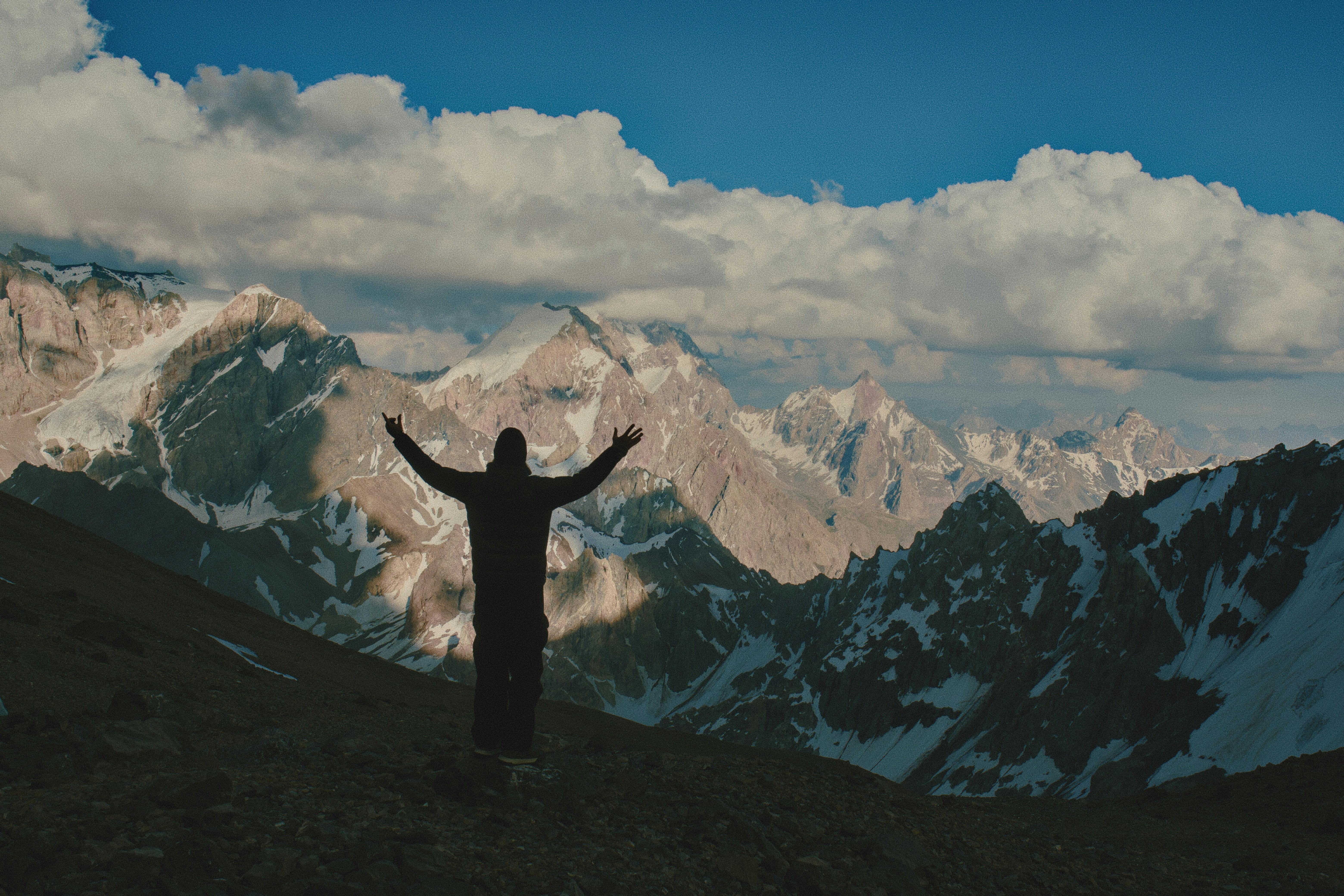 Hands to the Heavens: Silhouette Amid Alpine Peaks