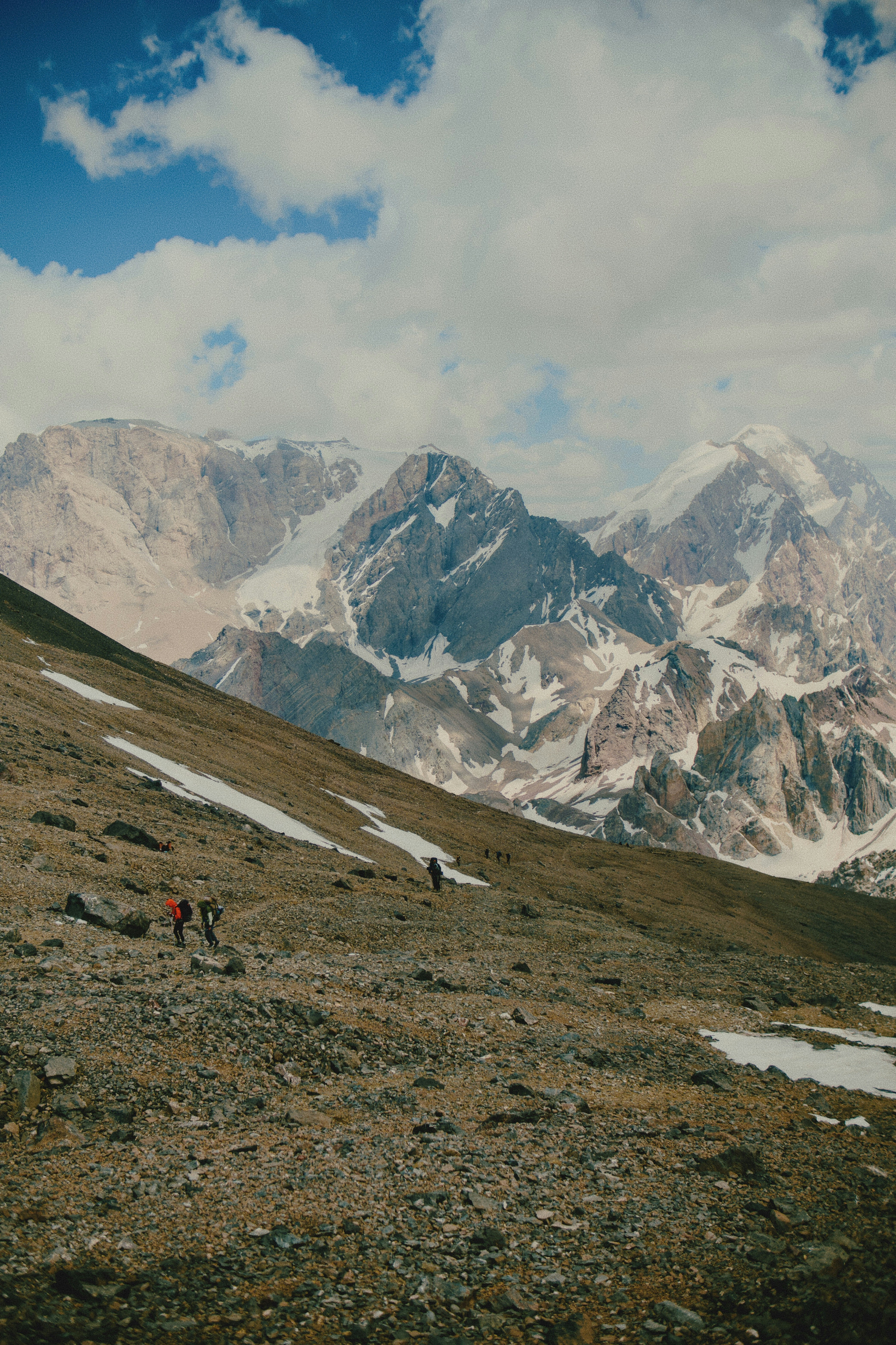 Trail of Climbers Against a Craggy Alpine Horizon