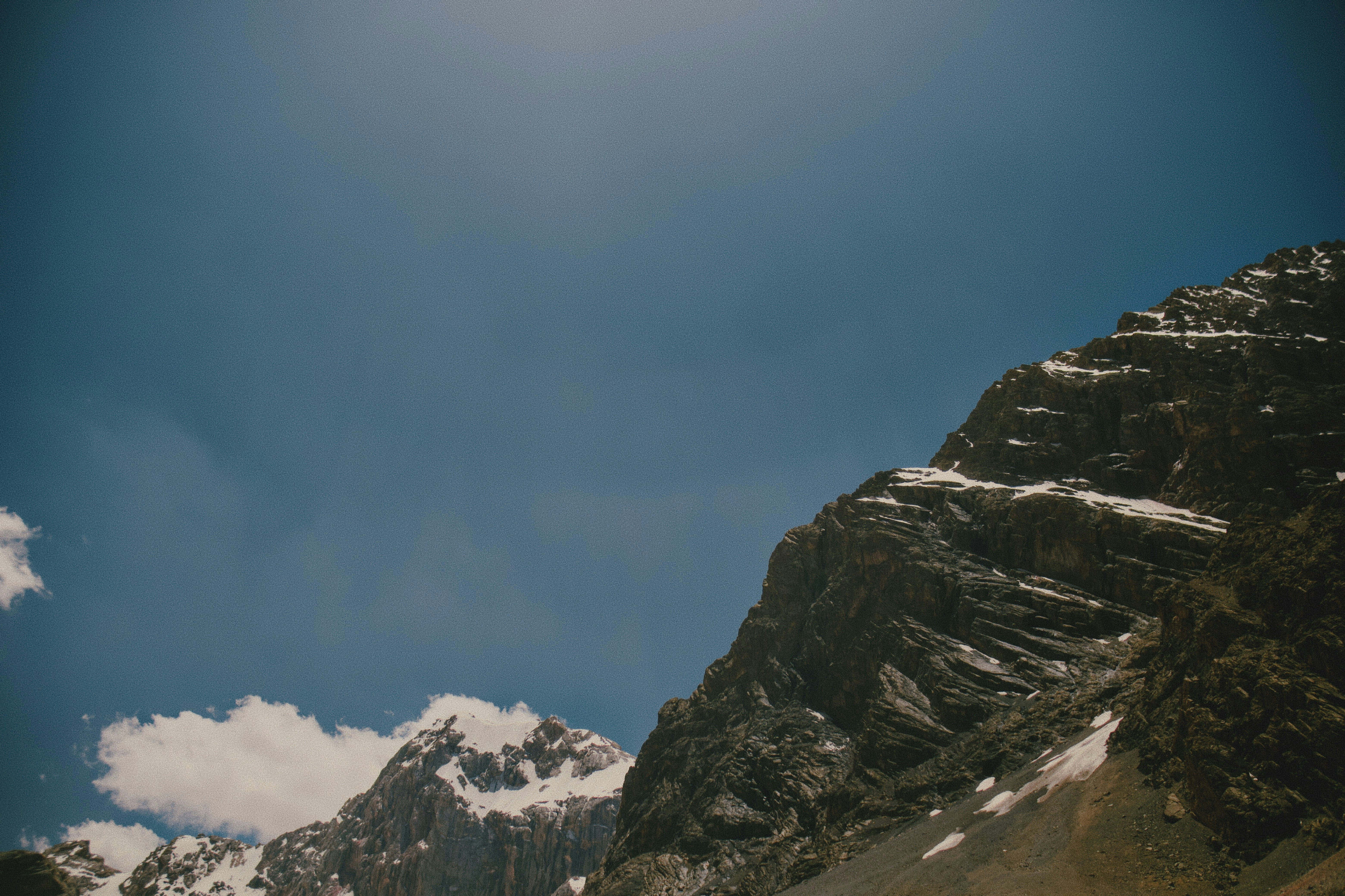 Snow-kissed cliffside under a clear alpine sky