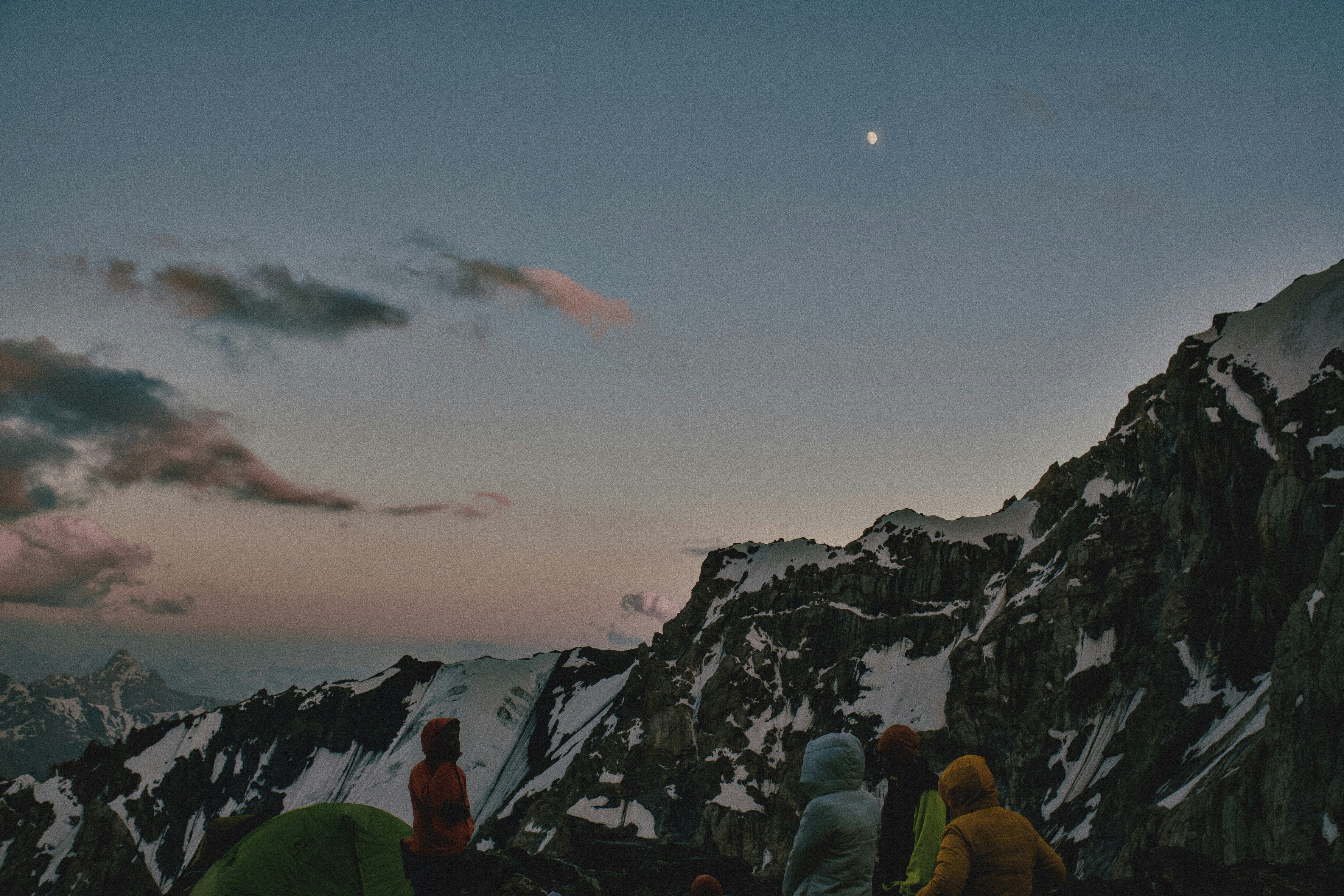 Summit Colleagues at Dusk: A Snow-Wedged Camp Amid Jagged Peaks