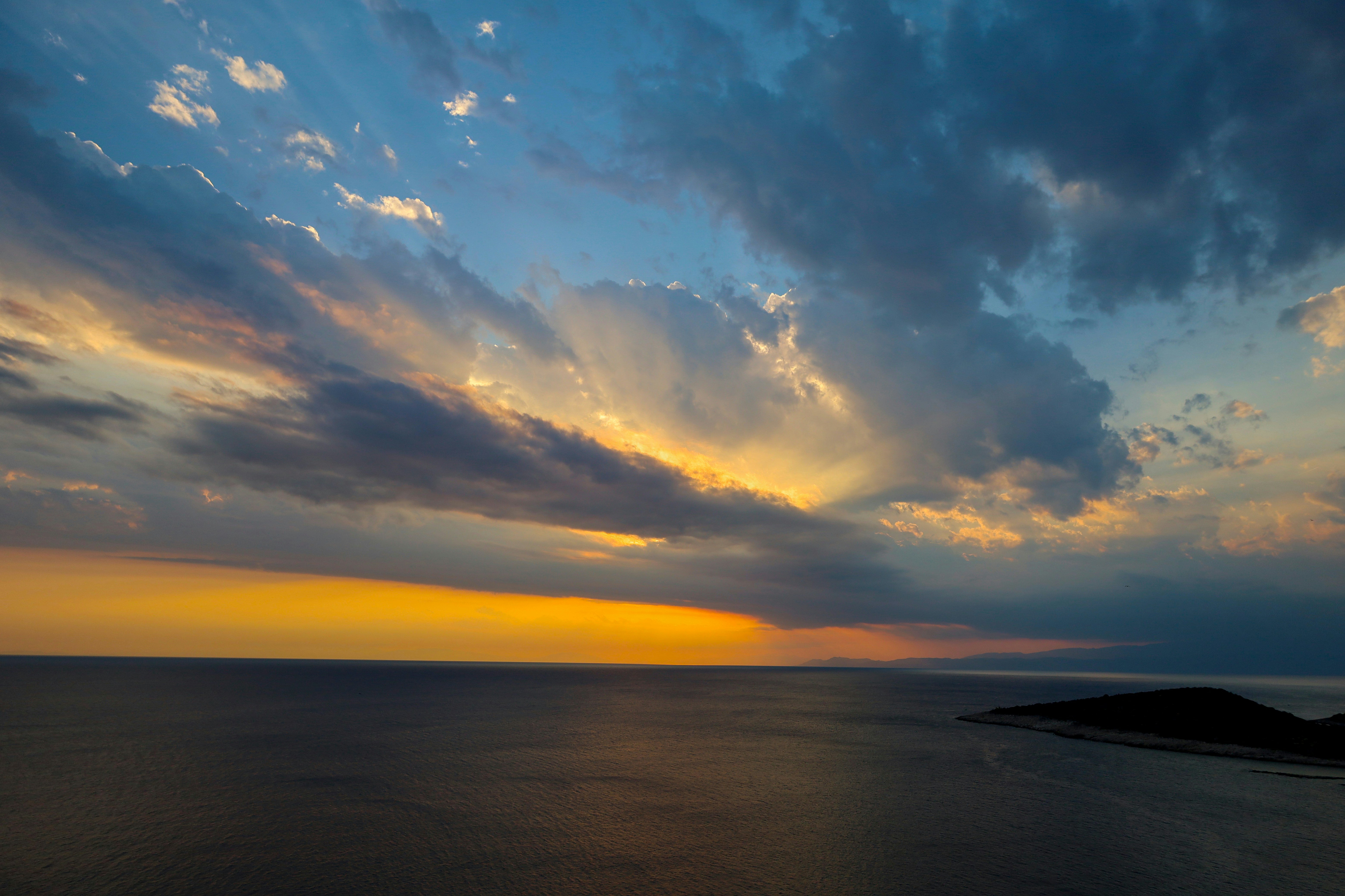 Dawn's Quiet Horizon: Sunlit Break over a Calm Sea