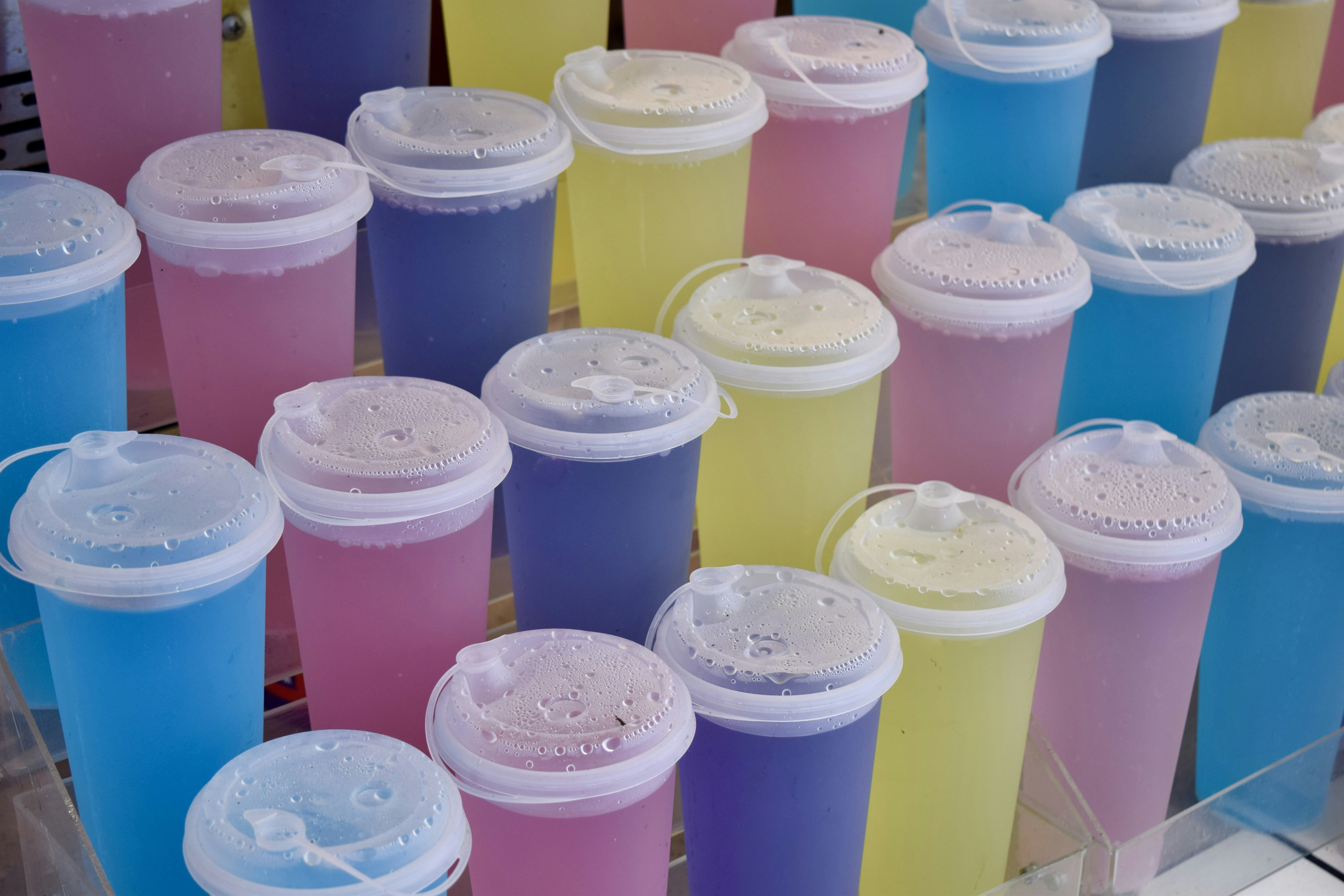 Row of Colorful Slushy Cups: A Rainbow Confection Standstill