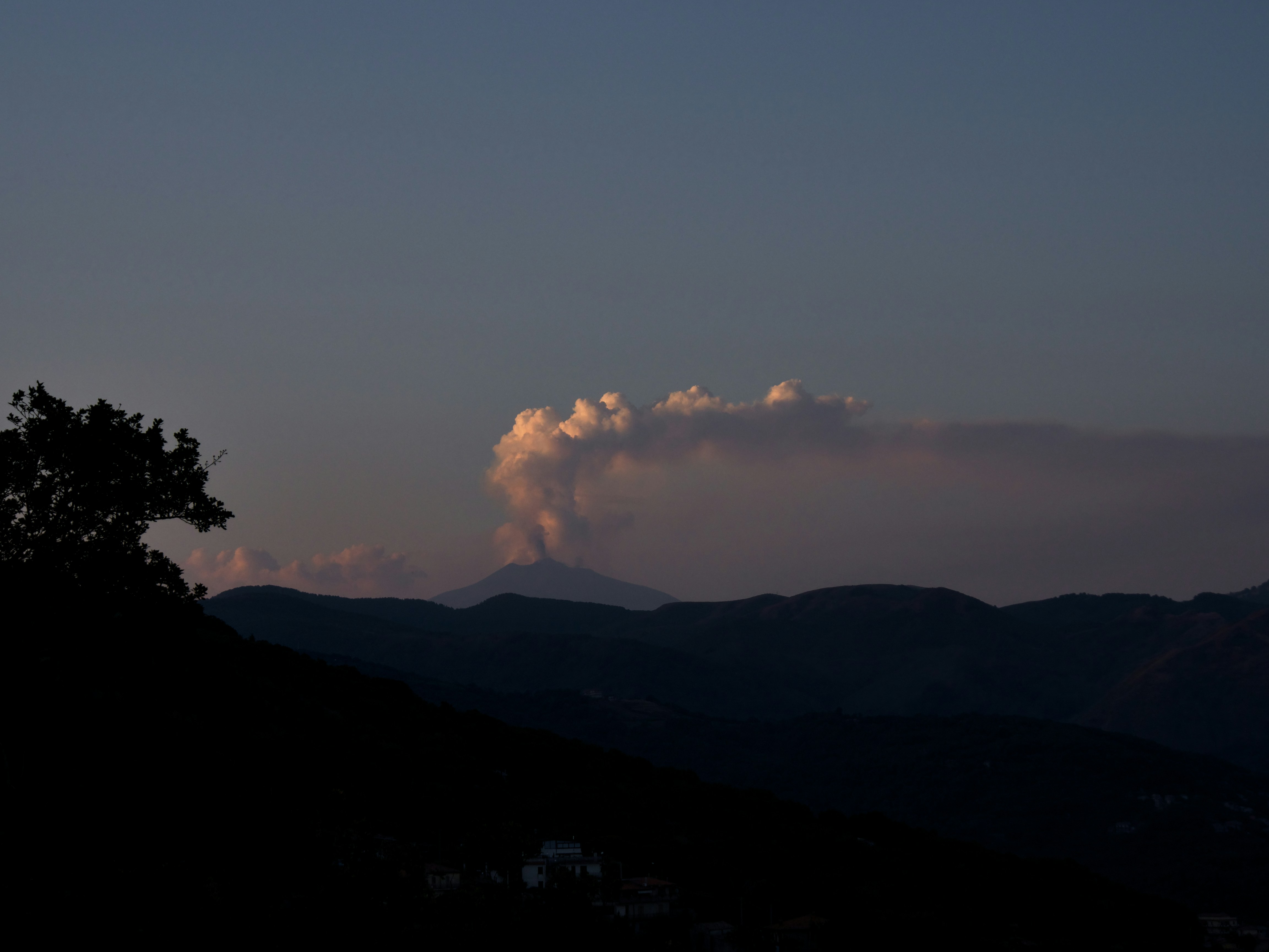 Distant Volcano Emerges from Evening Mist over Quiet Hills