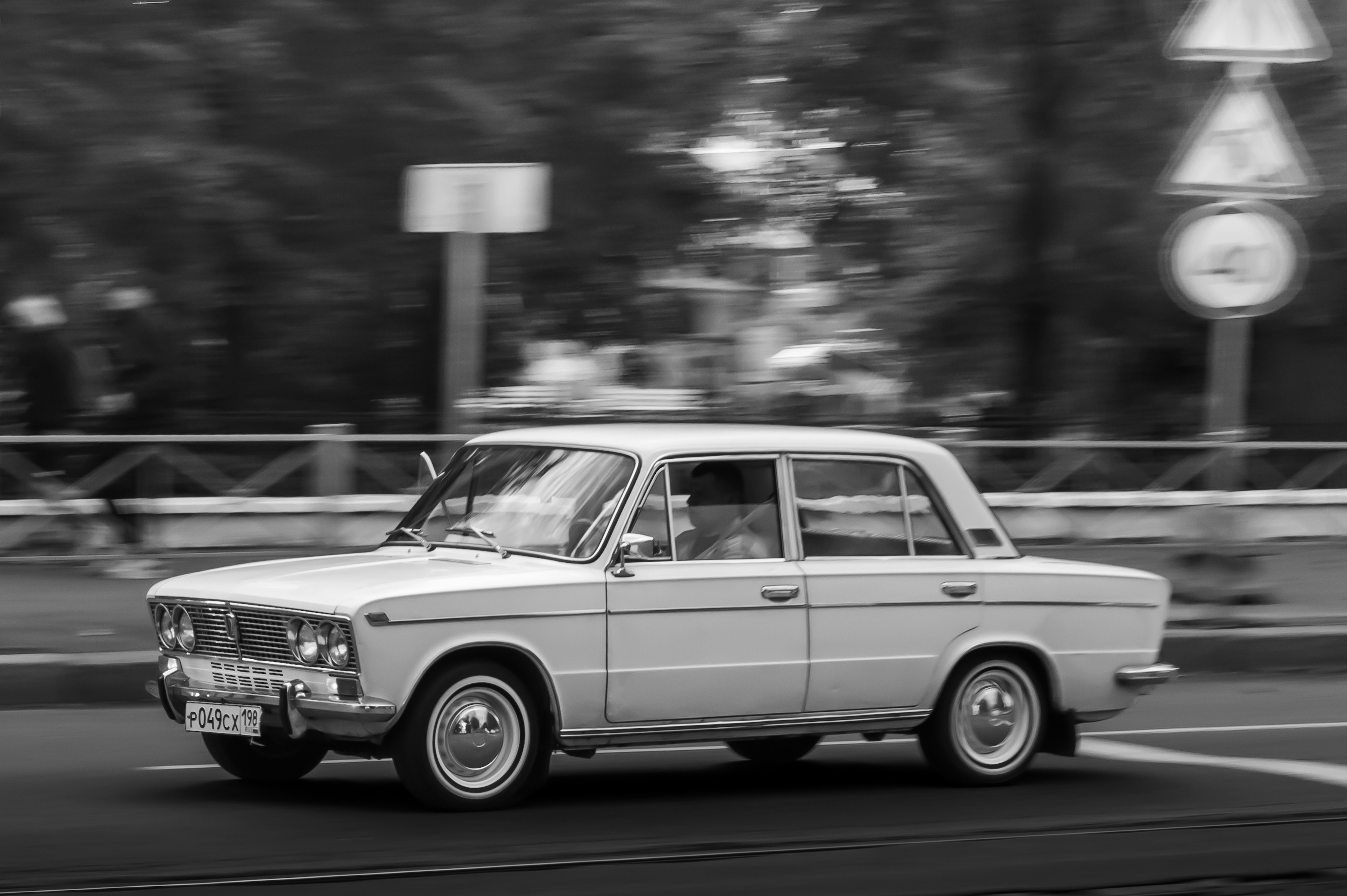 Mid‑Century Speed: A silver sedan glides past in a quiet blur