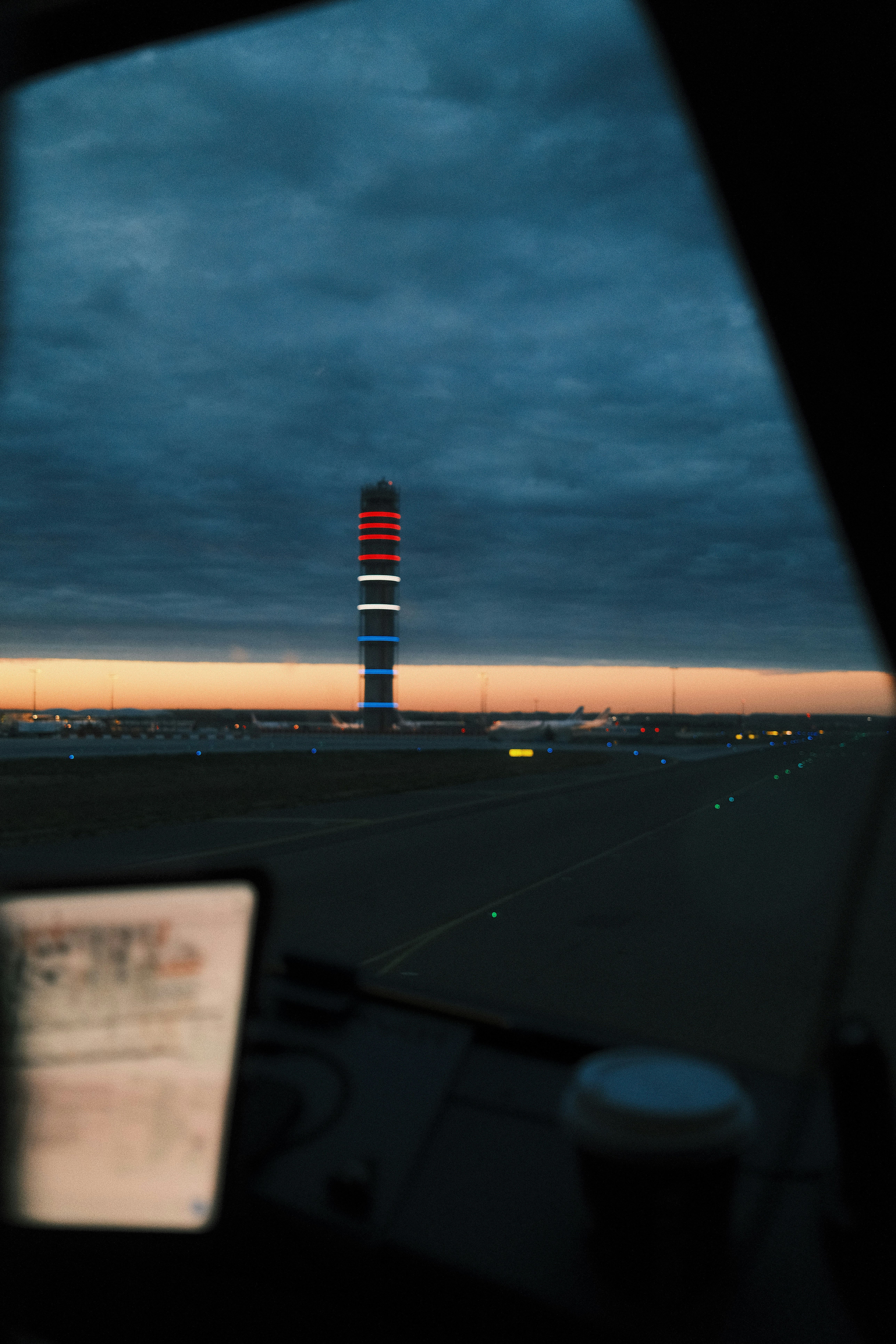 Bright beacon on a dim runway: the control tower hums against a twilight sky