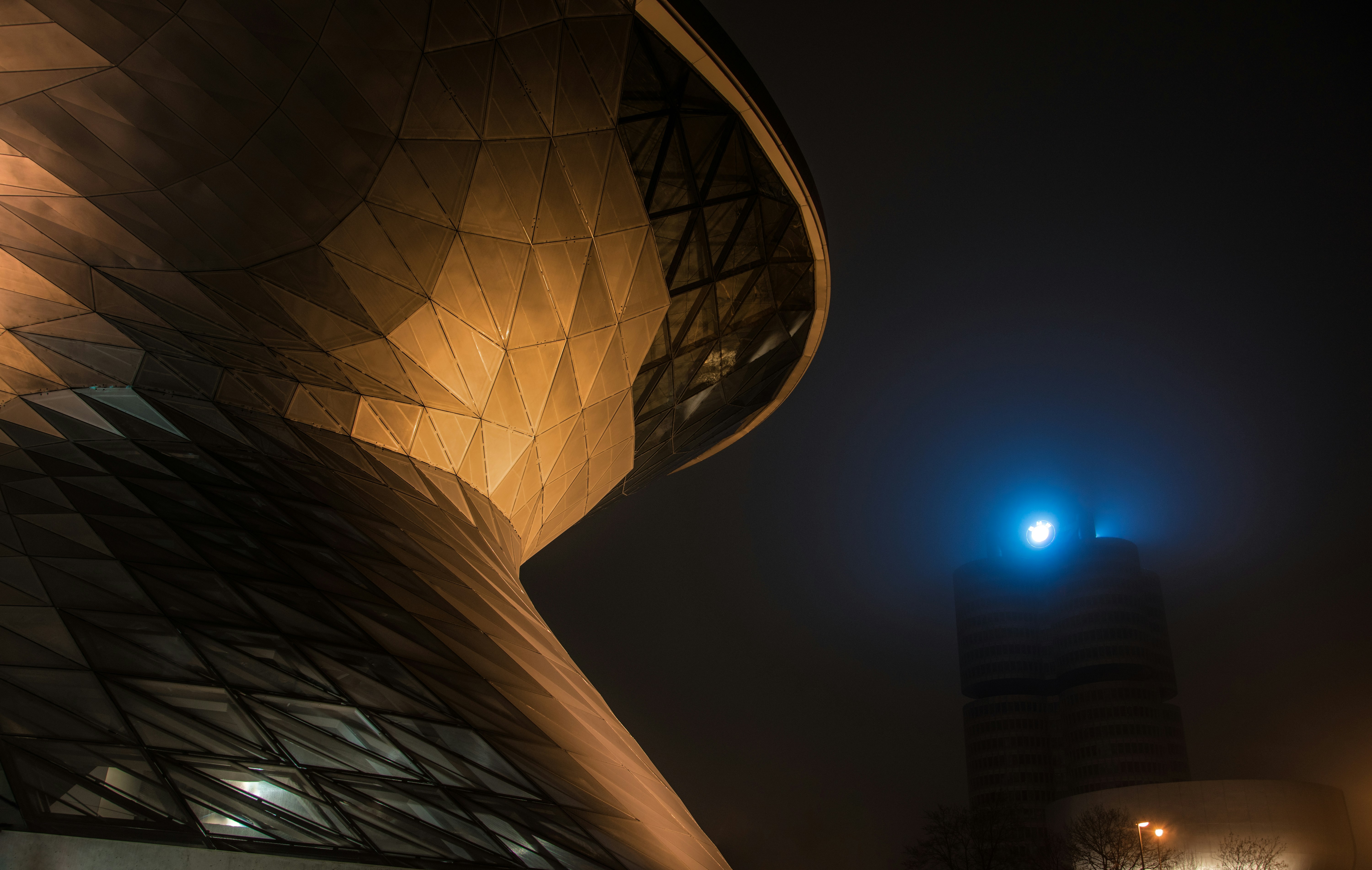 Glowing Skyline Behind Curved Facade: Night at the Modern Arena