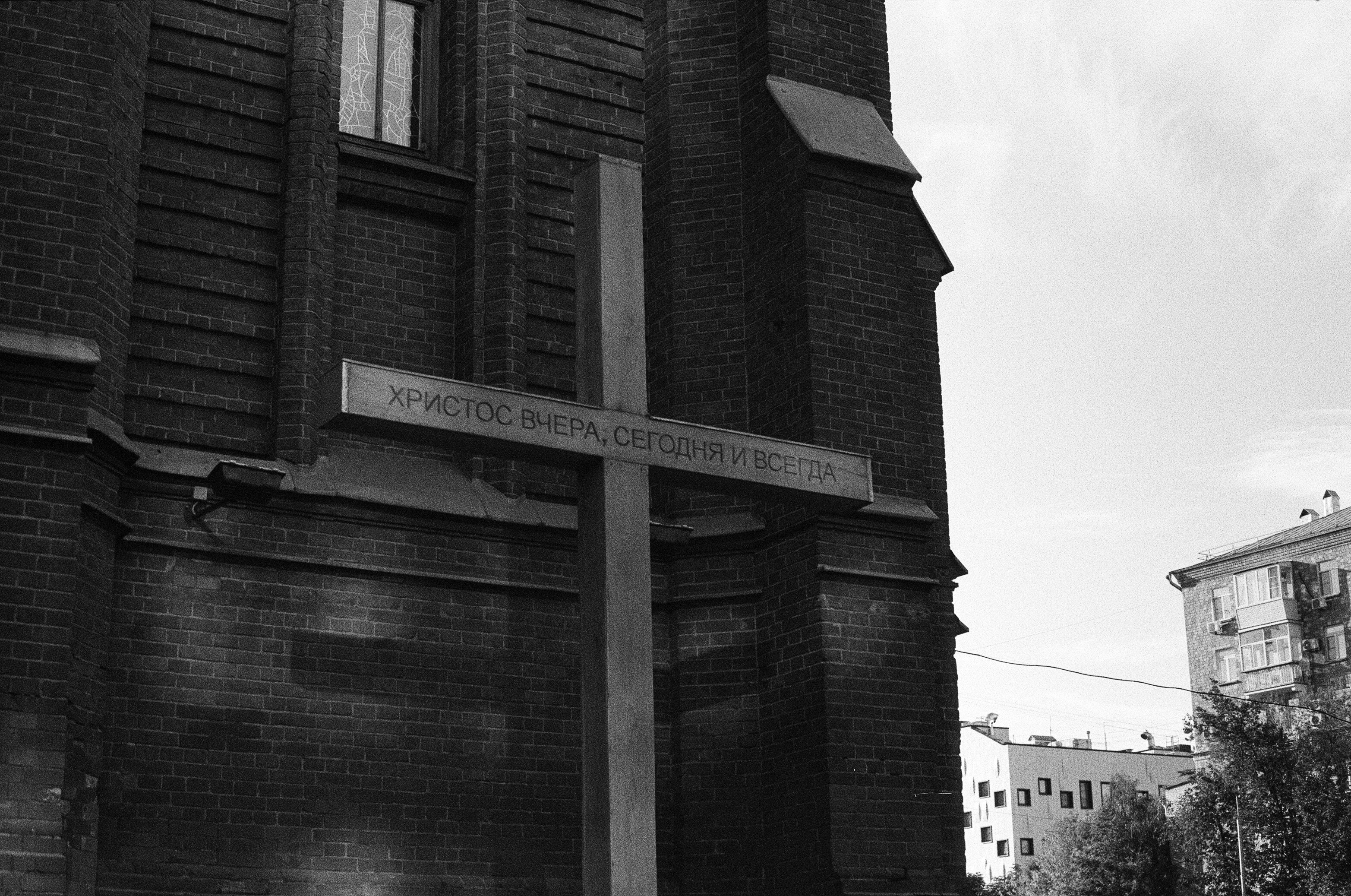 Crossroads of Faith: A weathered brick church and street sign in a quiet urban corner