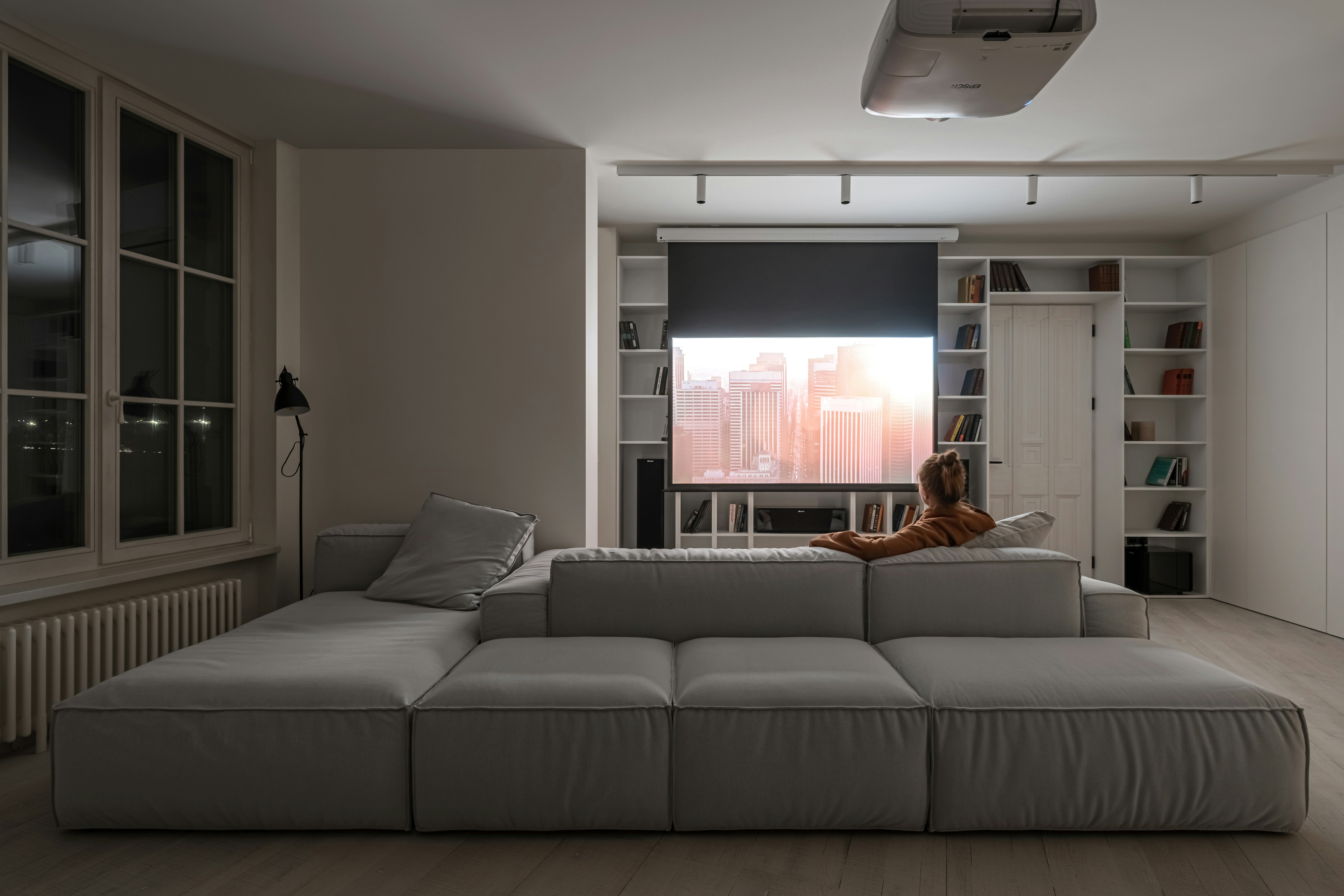 Cozy Living Room Cinema: A Quiet Evening with City Lights through the Window