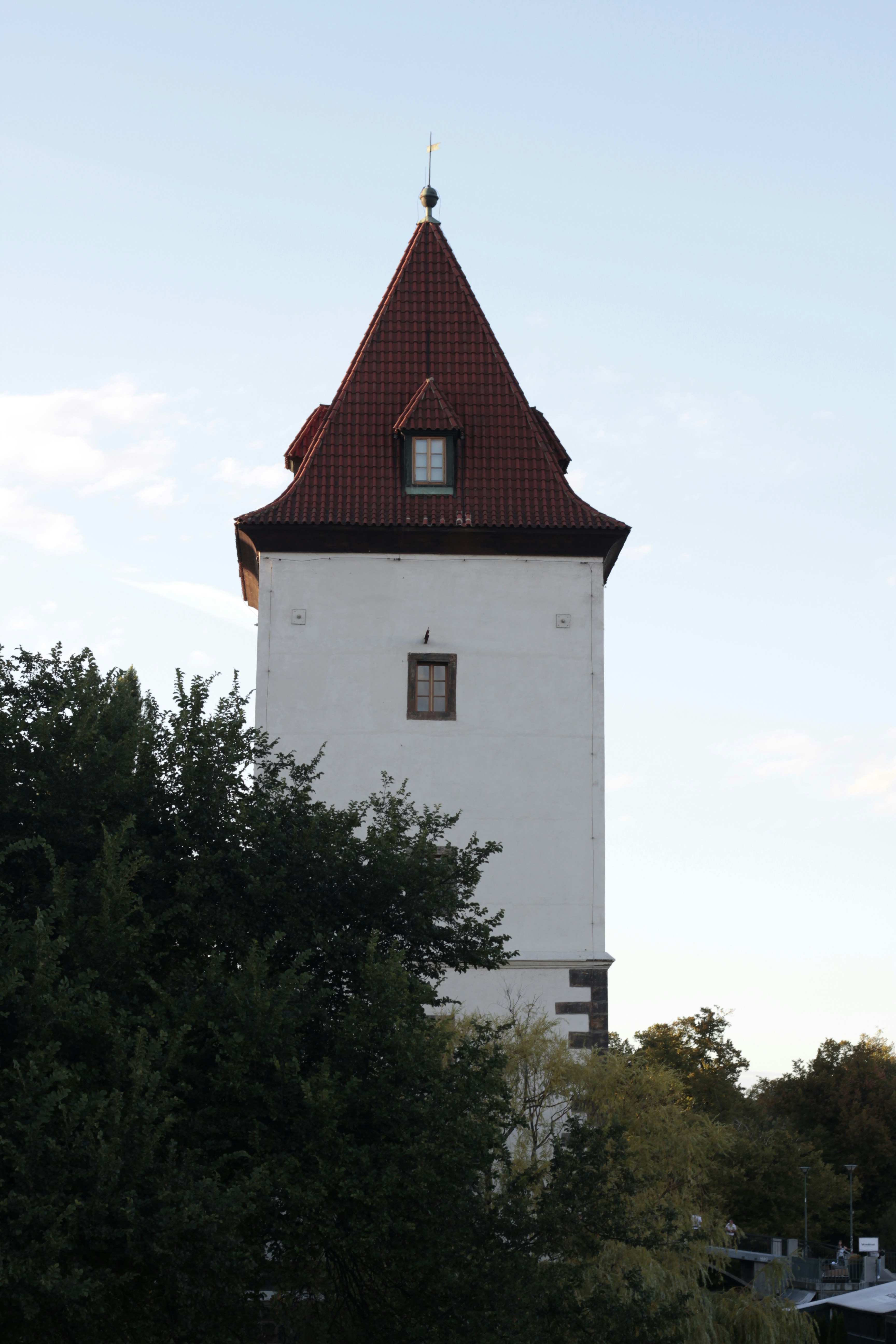 White Tower with Red-Tiled Roof Reaching Toward a Clear Sky