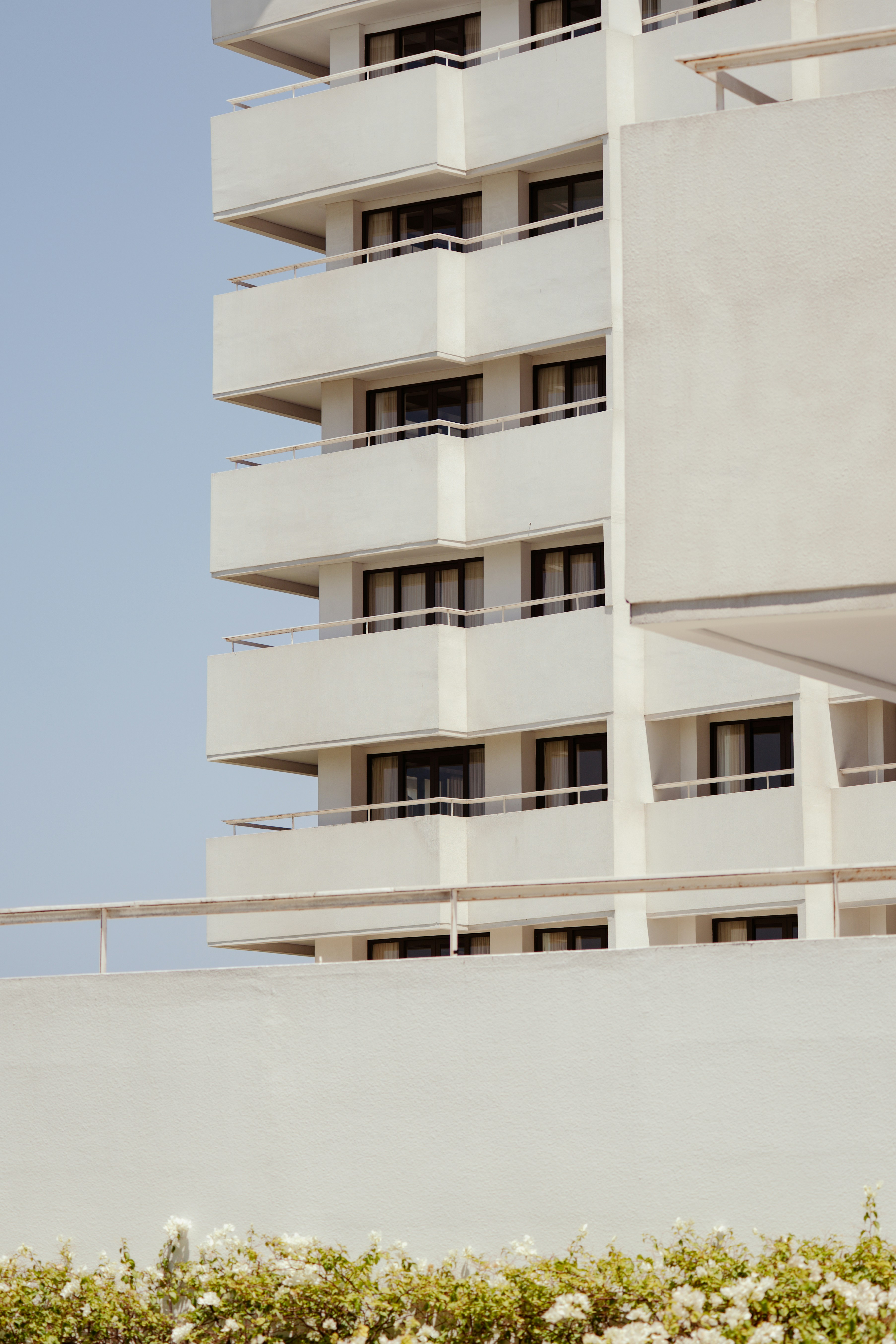 Aligned Concrete: Minimalist Balcony Facade Under a Clear Sky