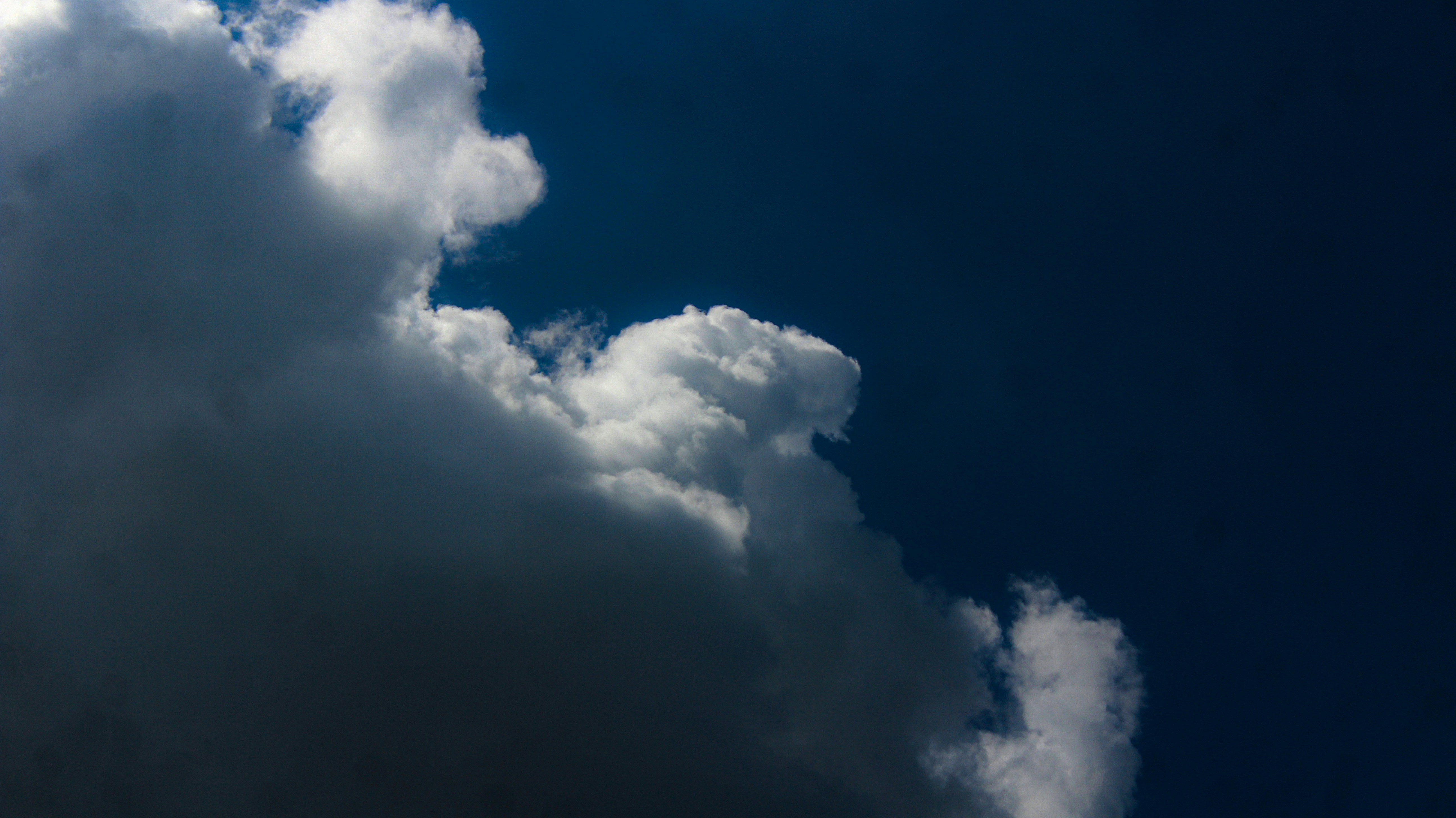 Deep blue sky with dramatic white clouds forming a bold profile, emphasizing negative space and natural light. (Not a logo, illustration, painting, or cartoon.)