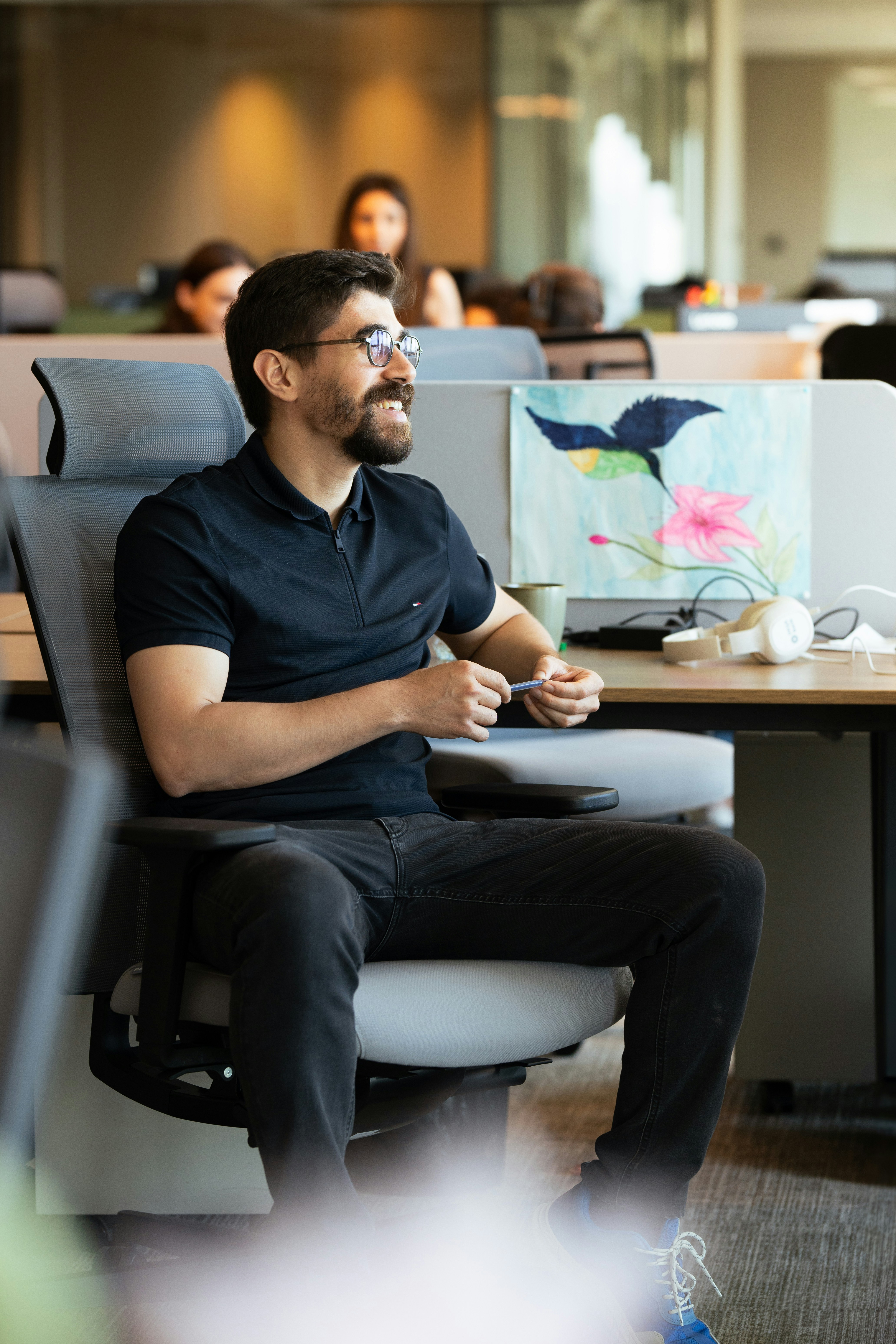 A smiling professional relaxing at his desk in a bright contemporary office
