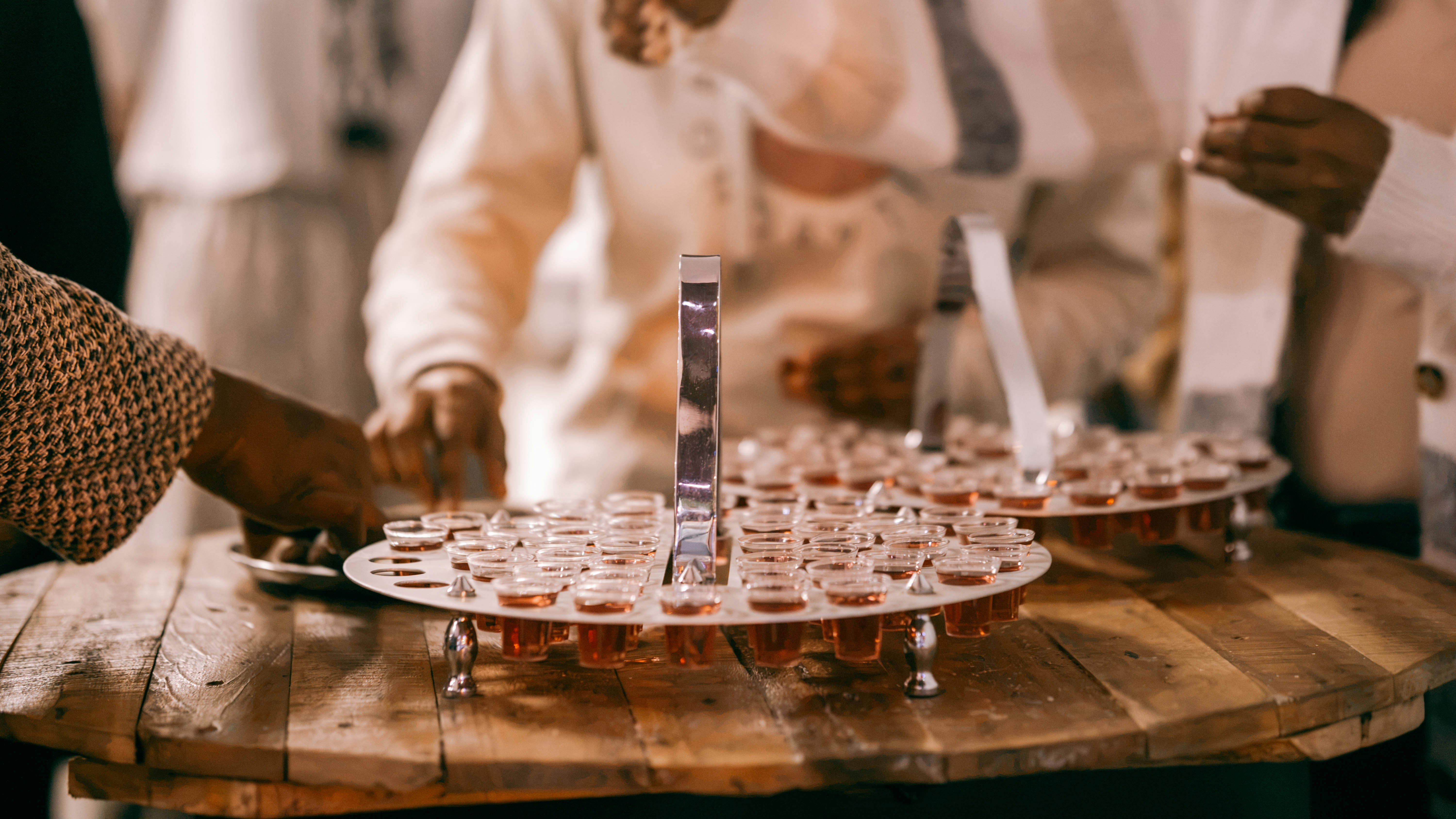 Gathered Cheers: Carousel of Tiny Glasses on a Rustic Table
