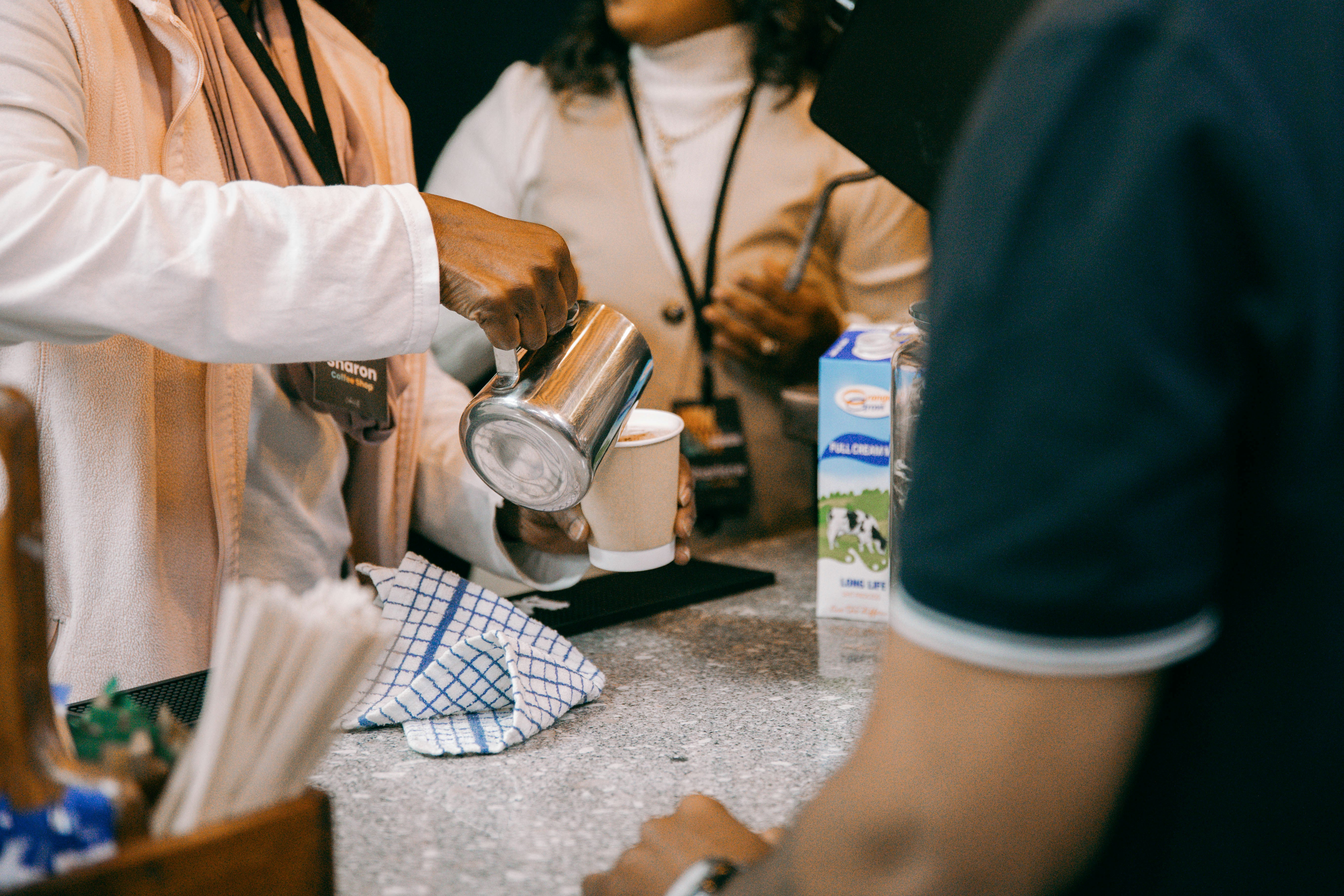Barista in Action: Pouring Steam Over a Coffee Counter