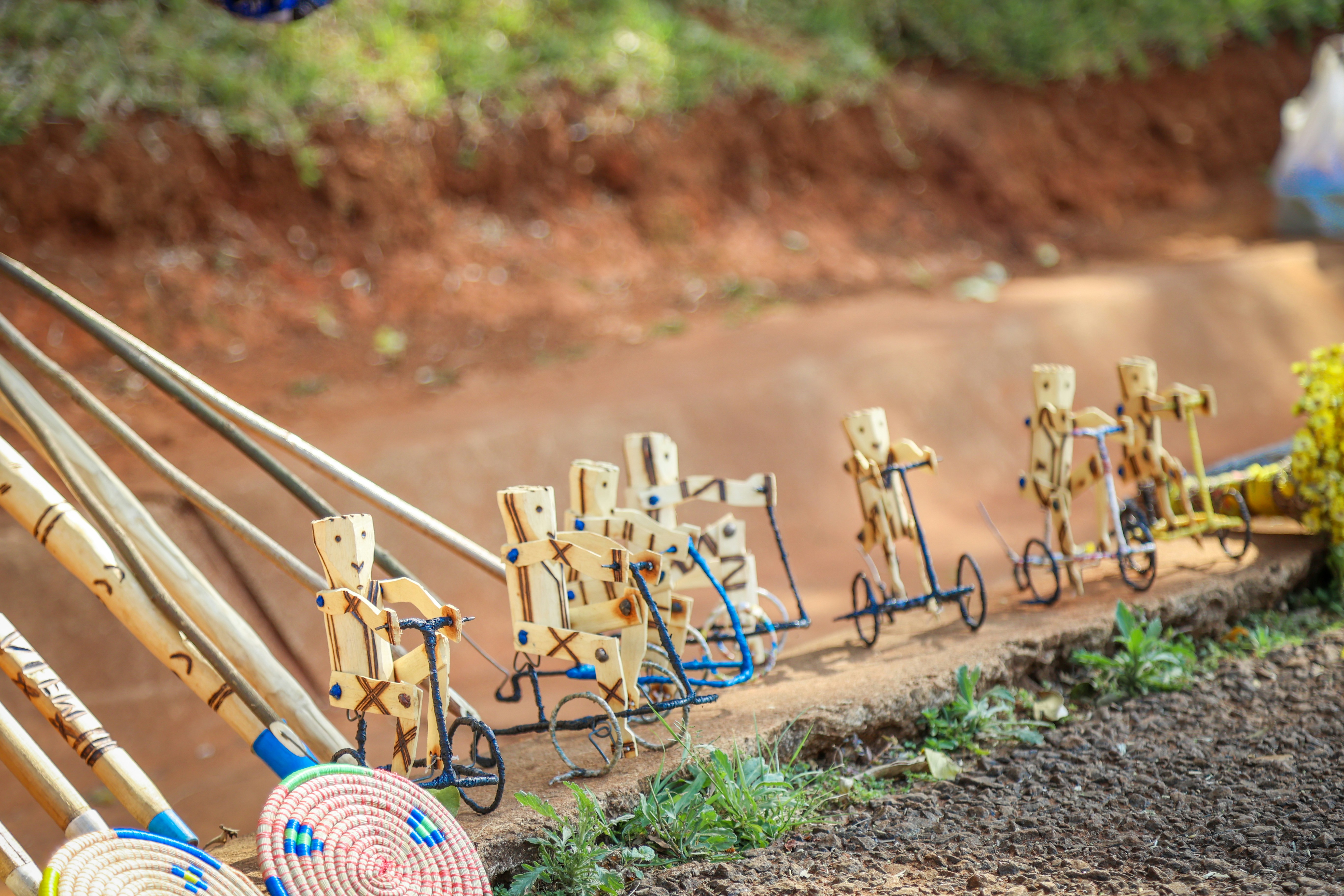 Rows of miniature wooden carts marching along a dirt curb