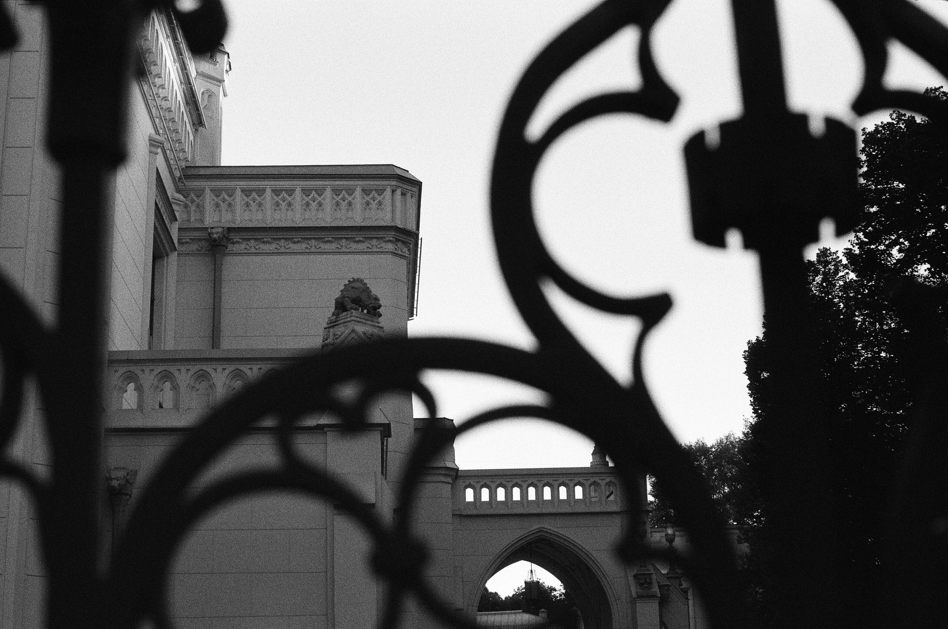 Archway through wrought iron: a glimpse of architecture beyond the fence
