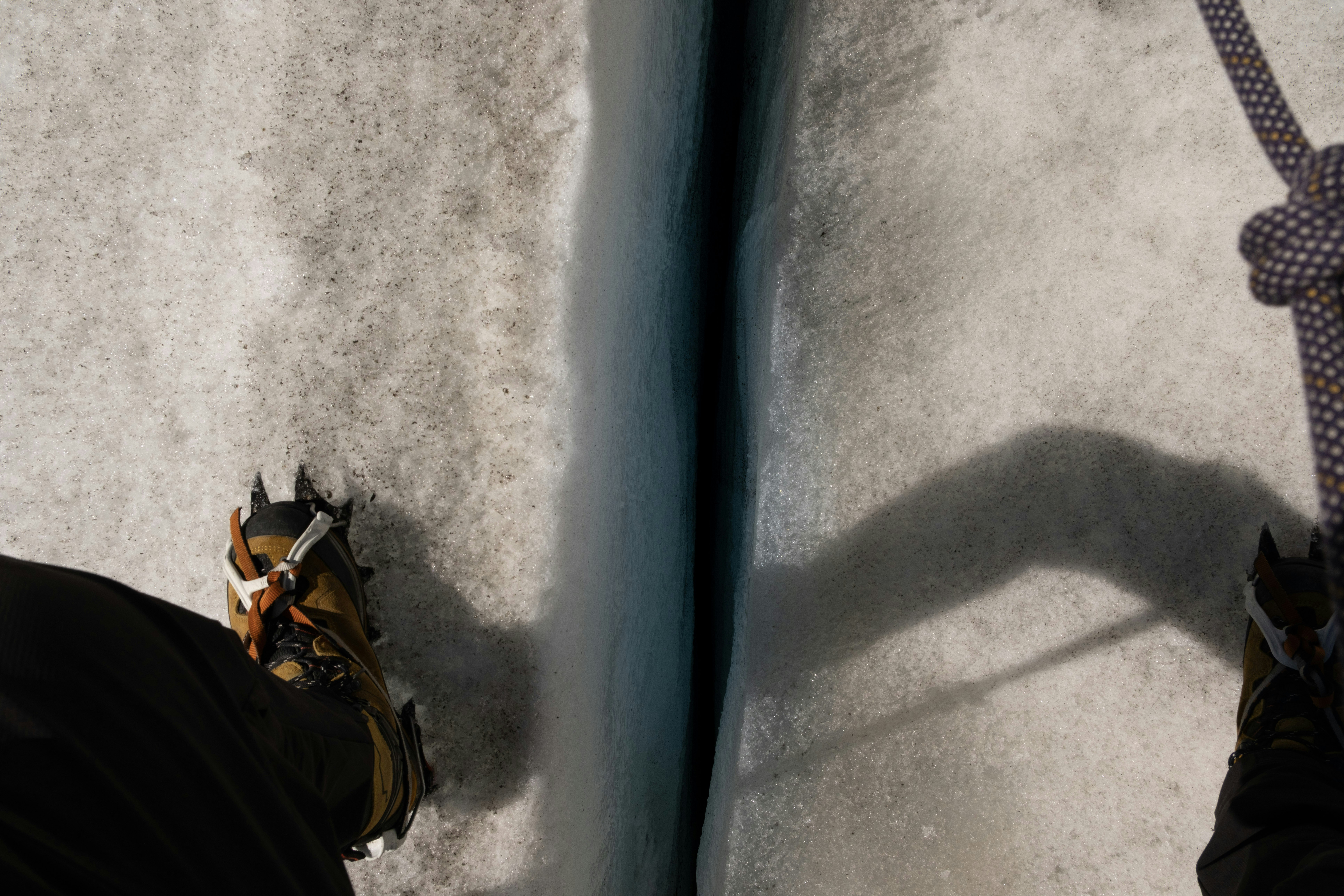 Ridge of Gravity: Climber's Shadow Over a Narrow Chasm
