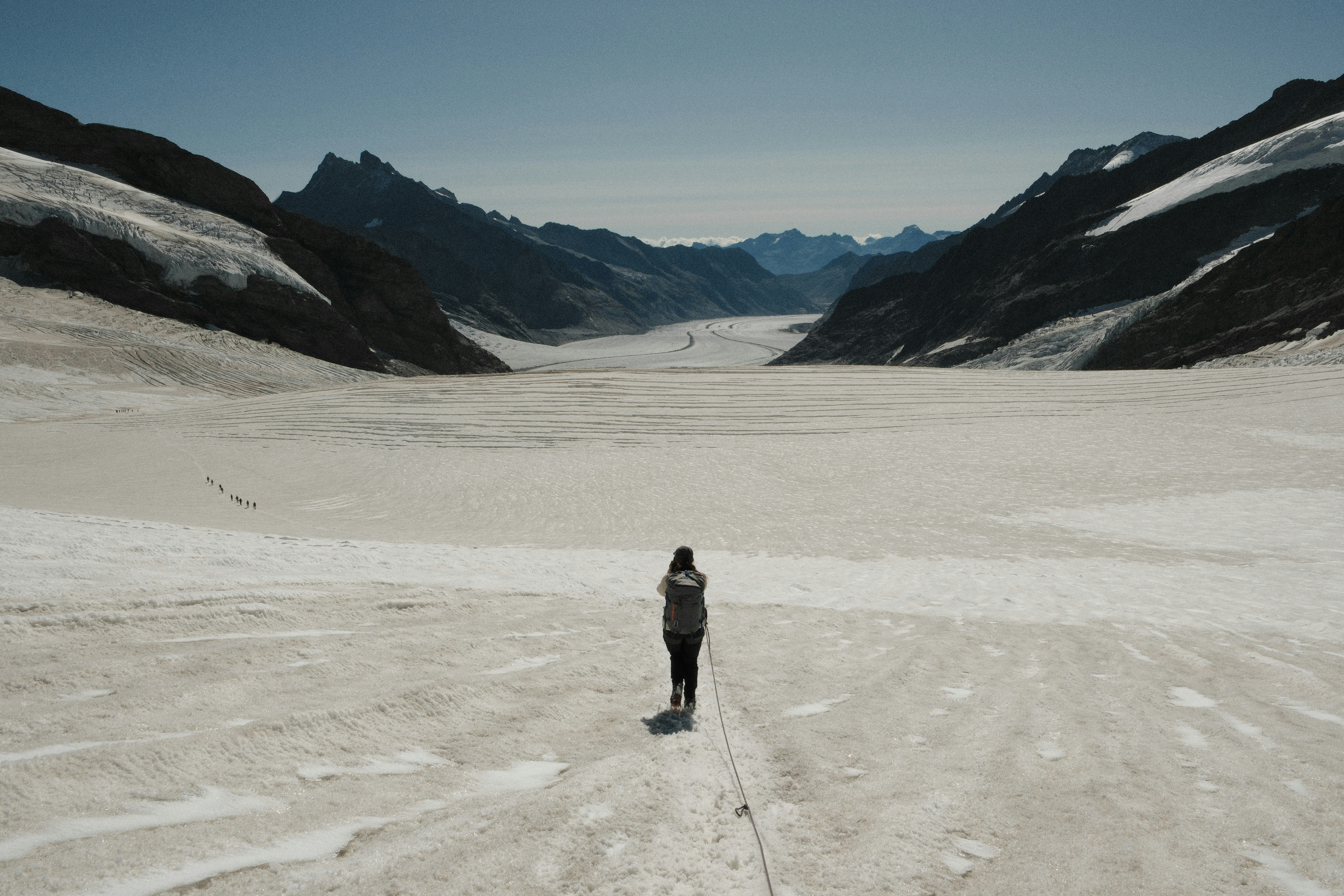 Alpine Path: A Lone Traveler Advances Through a Glacier Corridor