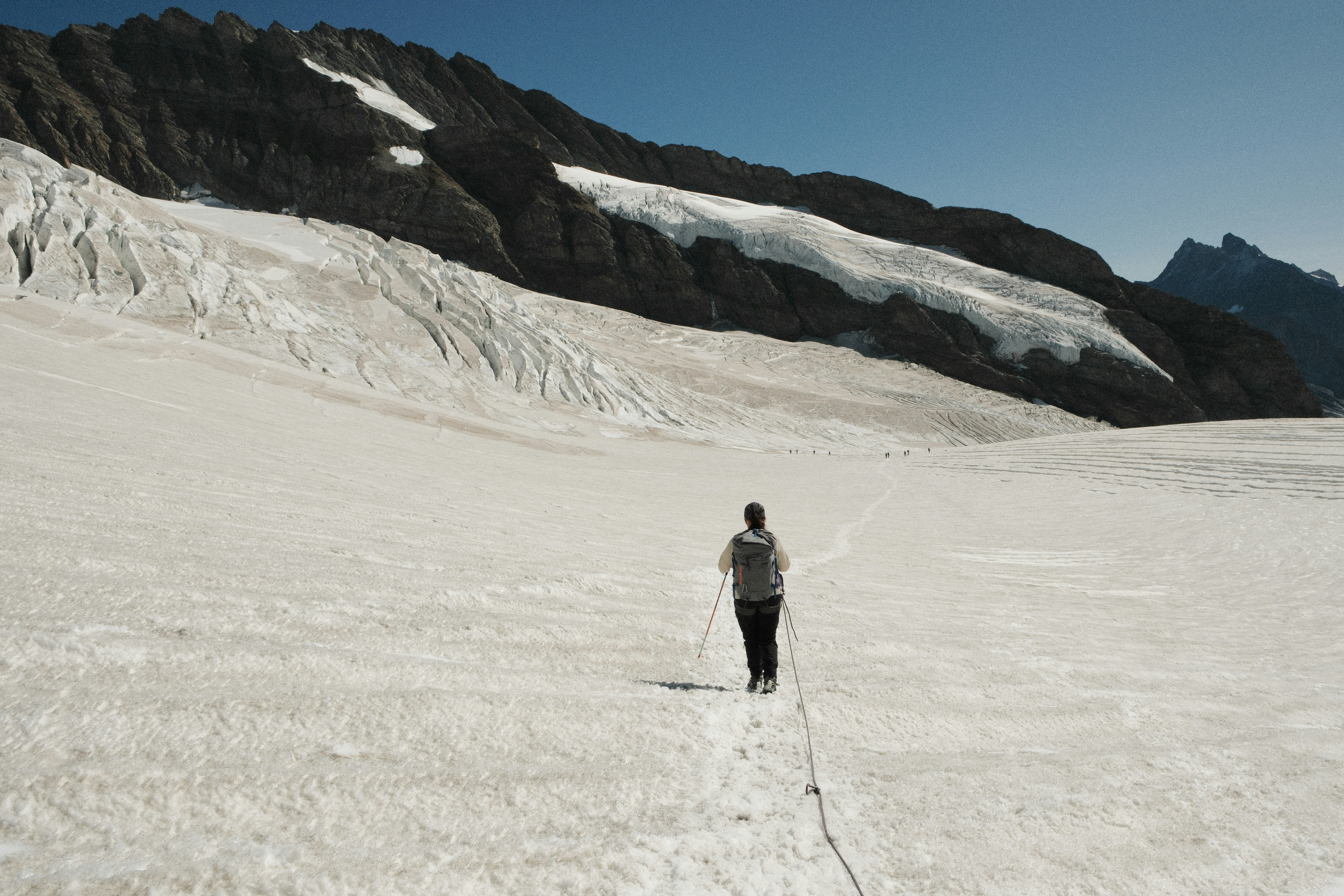 Trail to the Glacier: A Lone Hiker Crossing a Snow Field