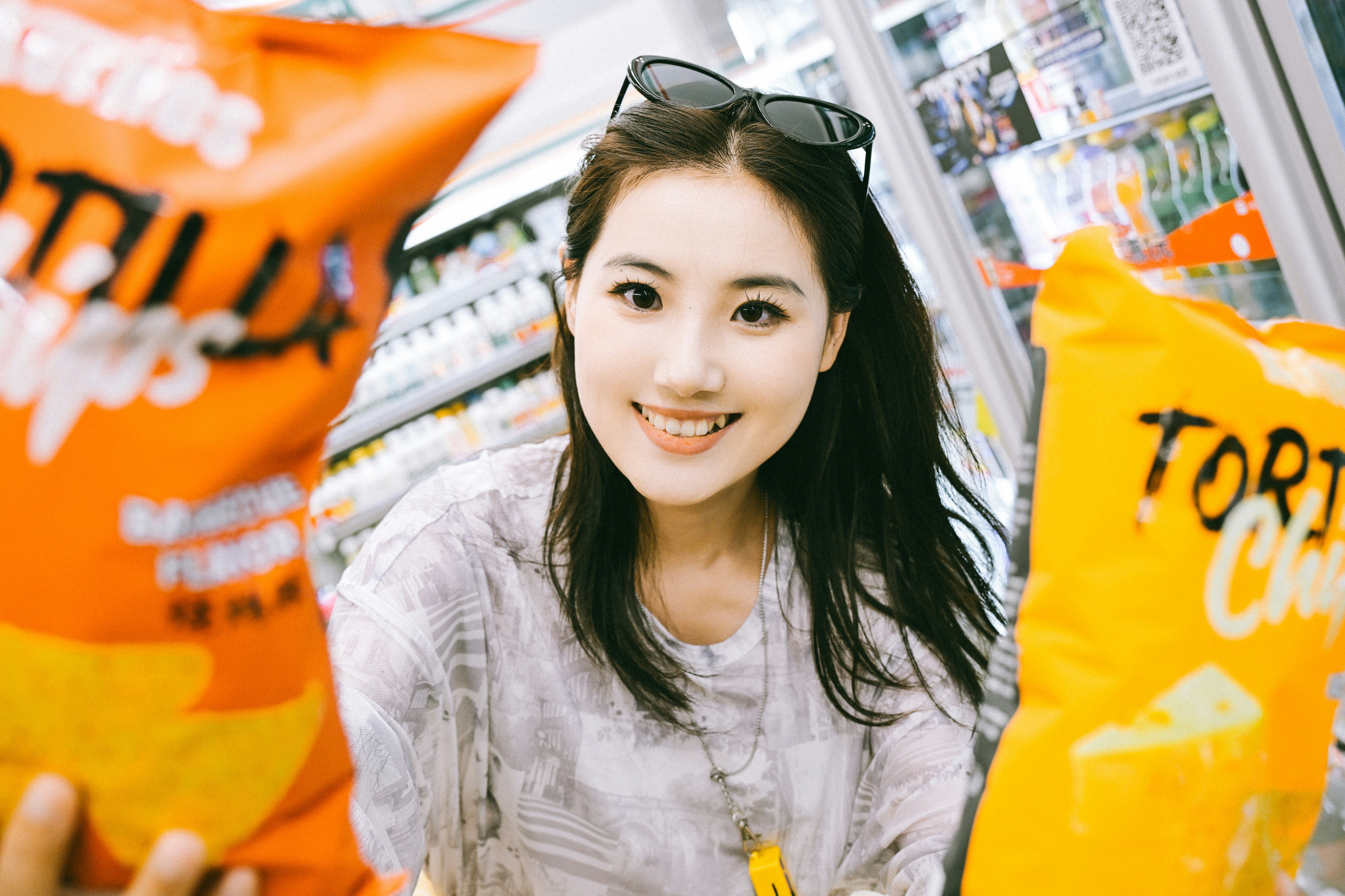 Smile in the Snack Aisle: A Portrait Among Orange Bags
