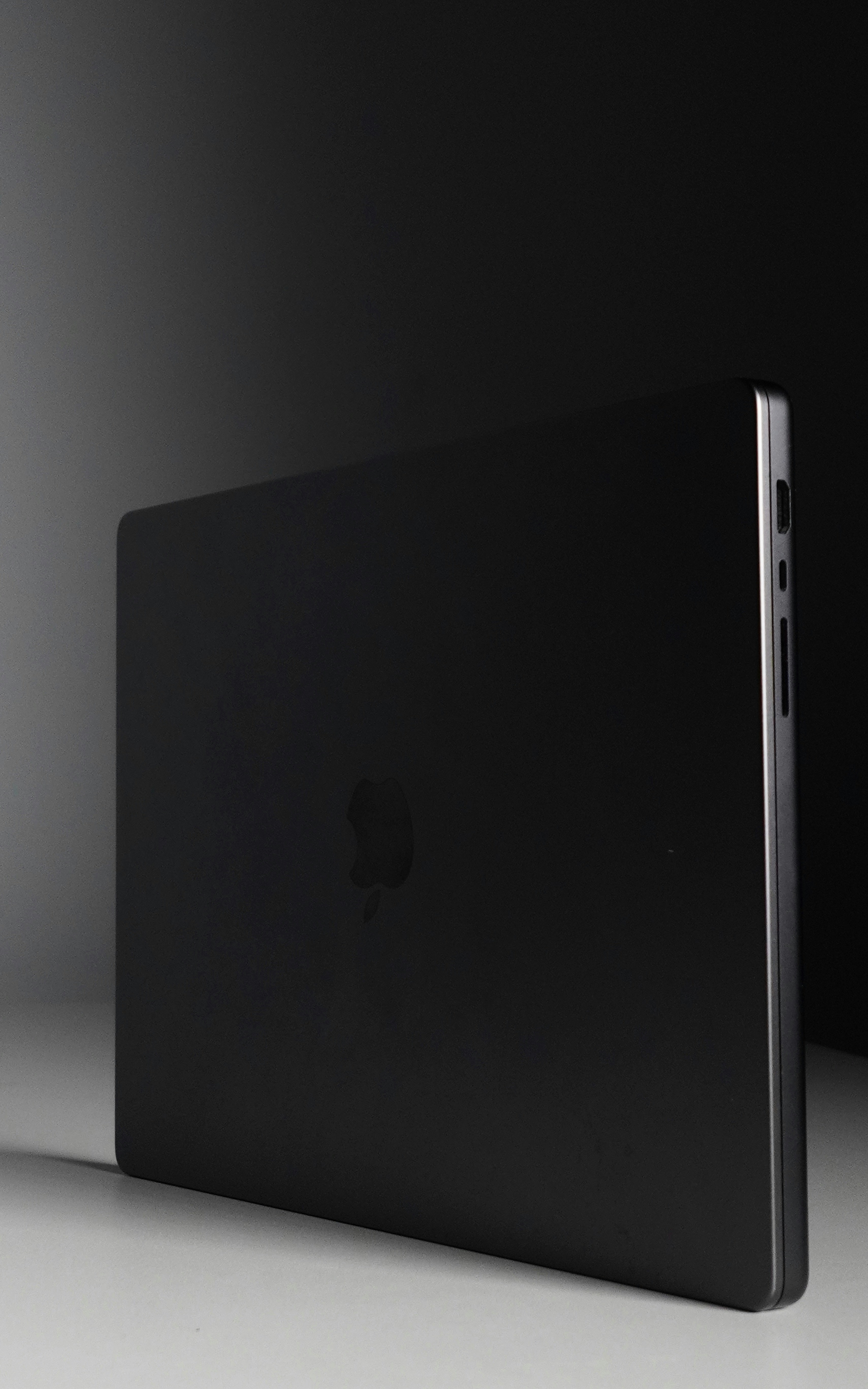 Monochrome precision: a matte-backed laptop standing tall on a soft shadowed surface