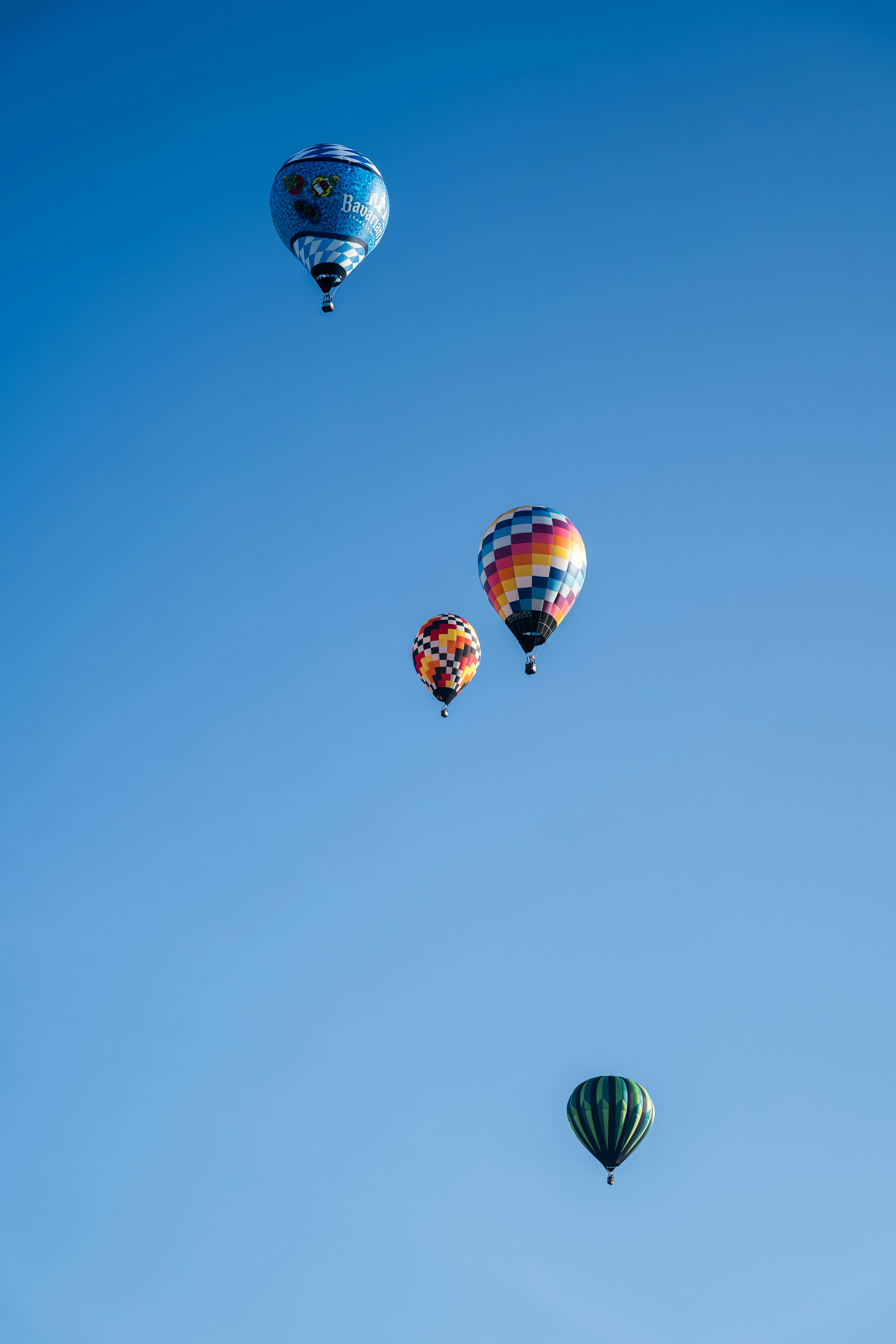 Blue Balloon Ascendant: Trio of Colorful Parcels Drifting in a Clear Sky