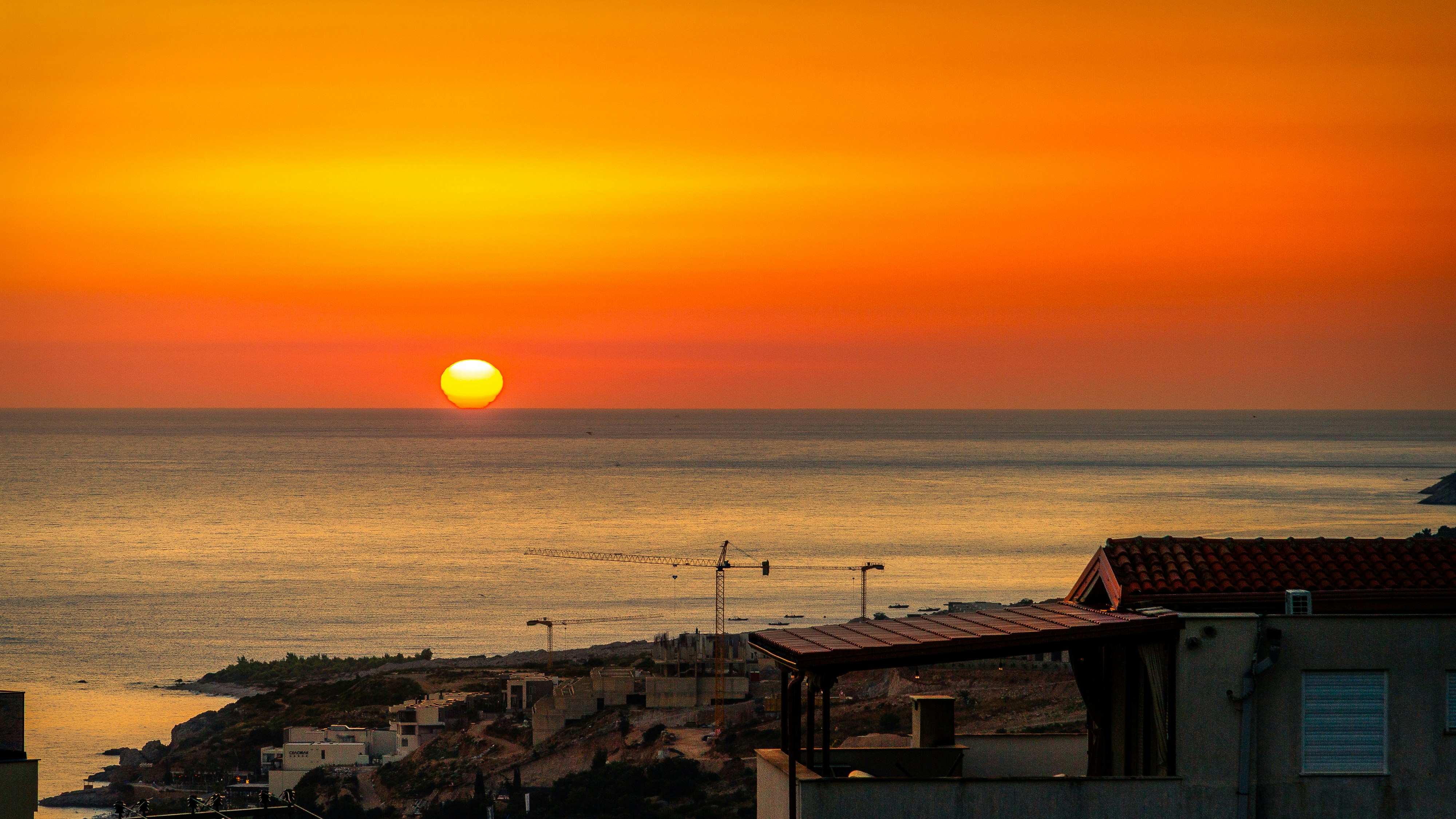 Sunset over calm harbor: warm horizon and silhouettes