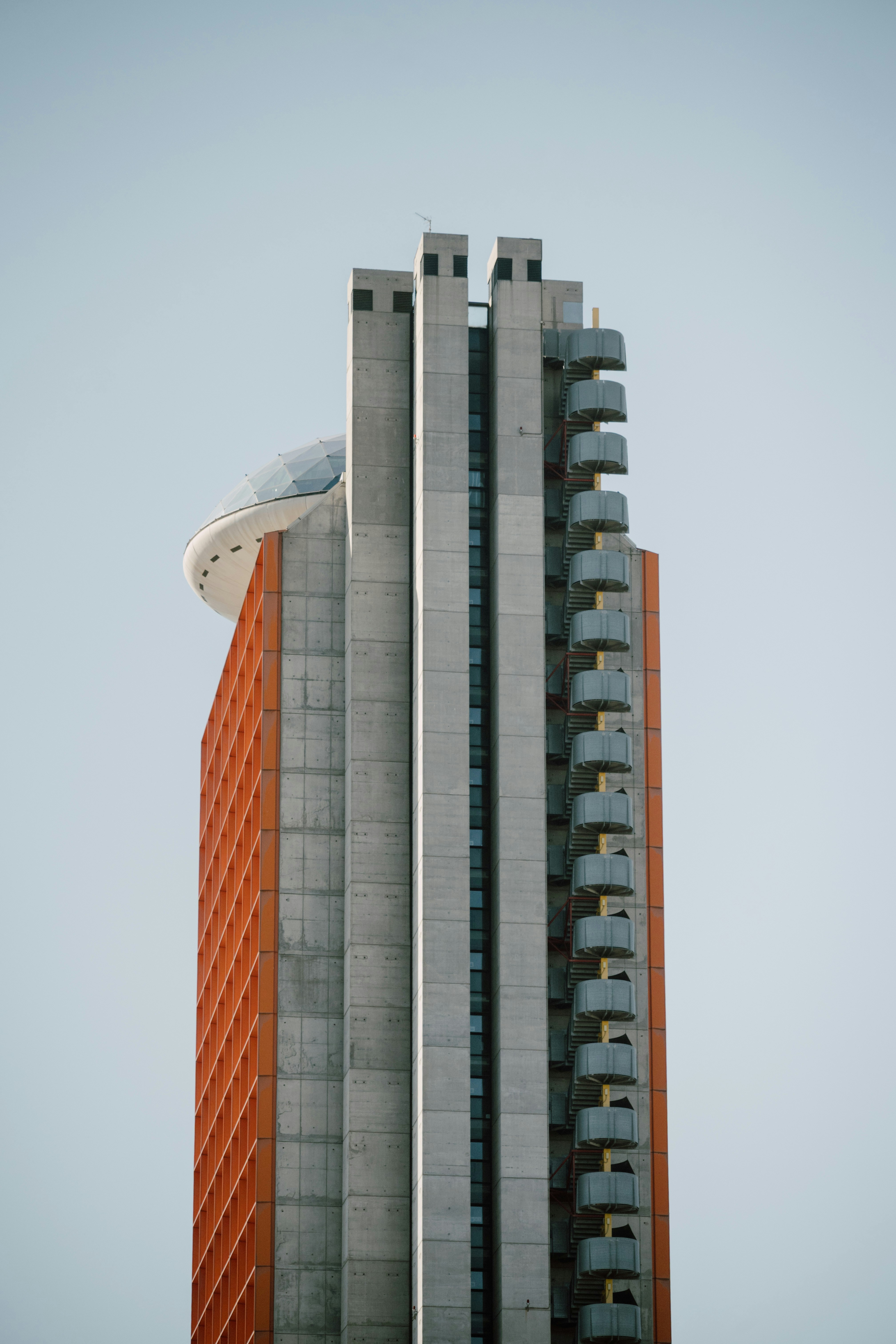 The Orange Tower: Modern Concrete Silhouette Against a Clear Sky
